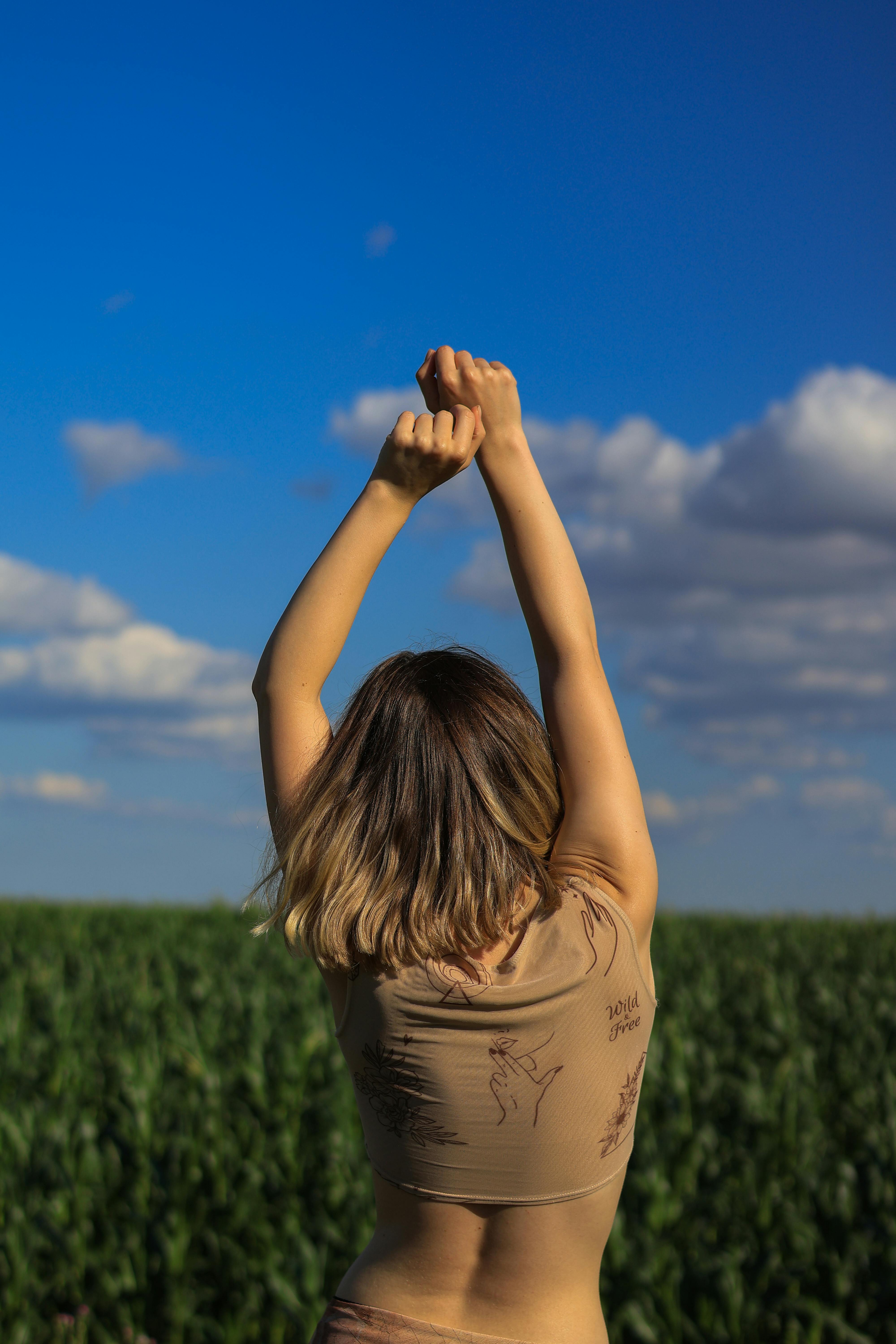 Back View of Woman Standing with Arms Raised · Free Stock Photo