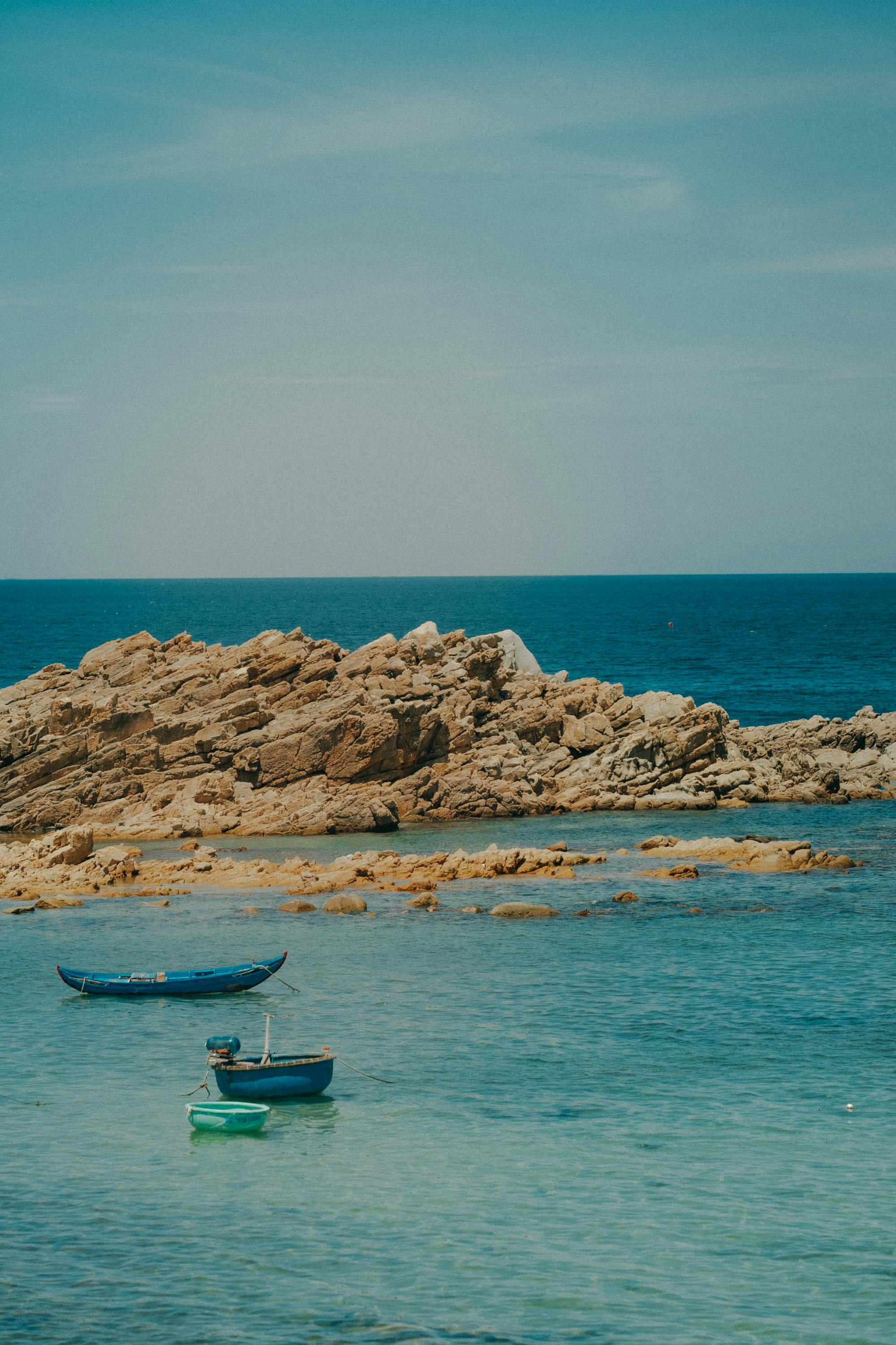 An Offshore Rock Formation Surrounded By Speedboats · Free Stock Photo