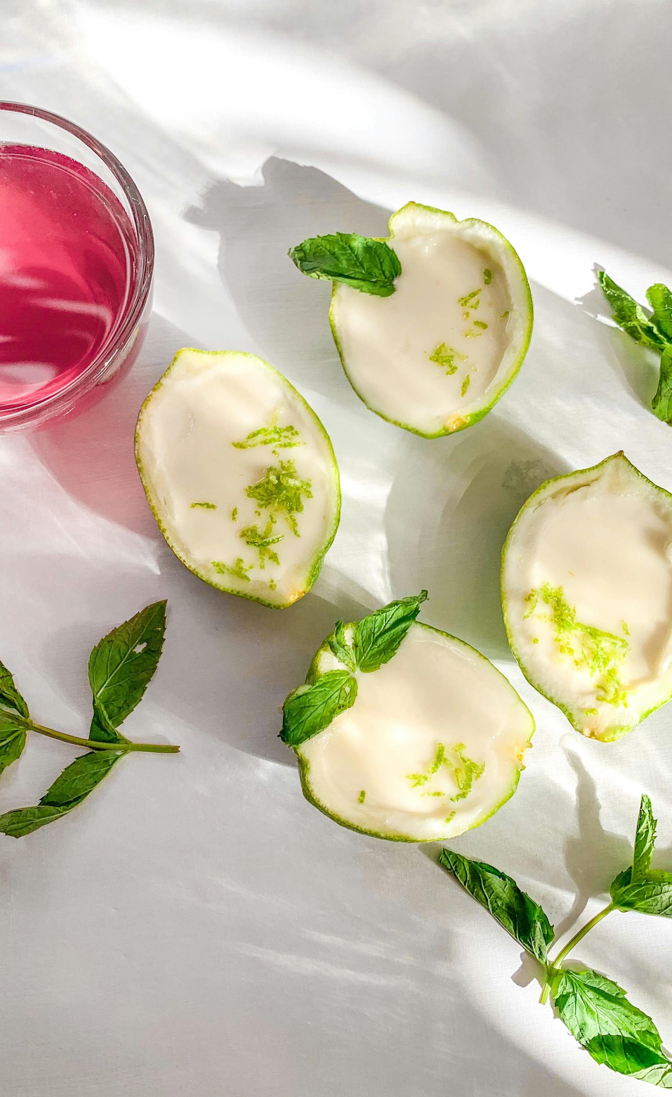White Cream Inside Limes on a White Background Between Leafs with a ...