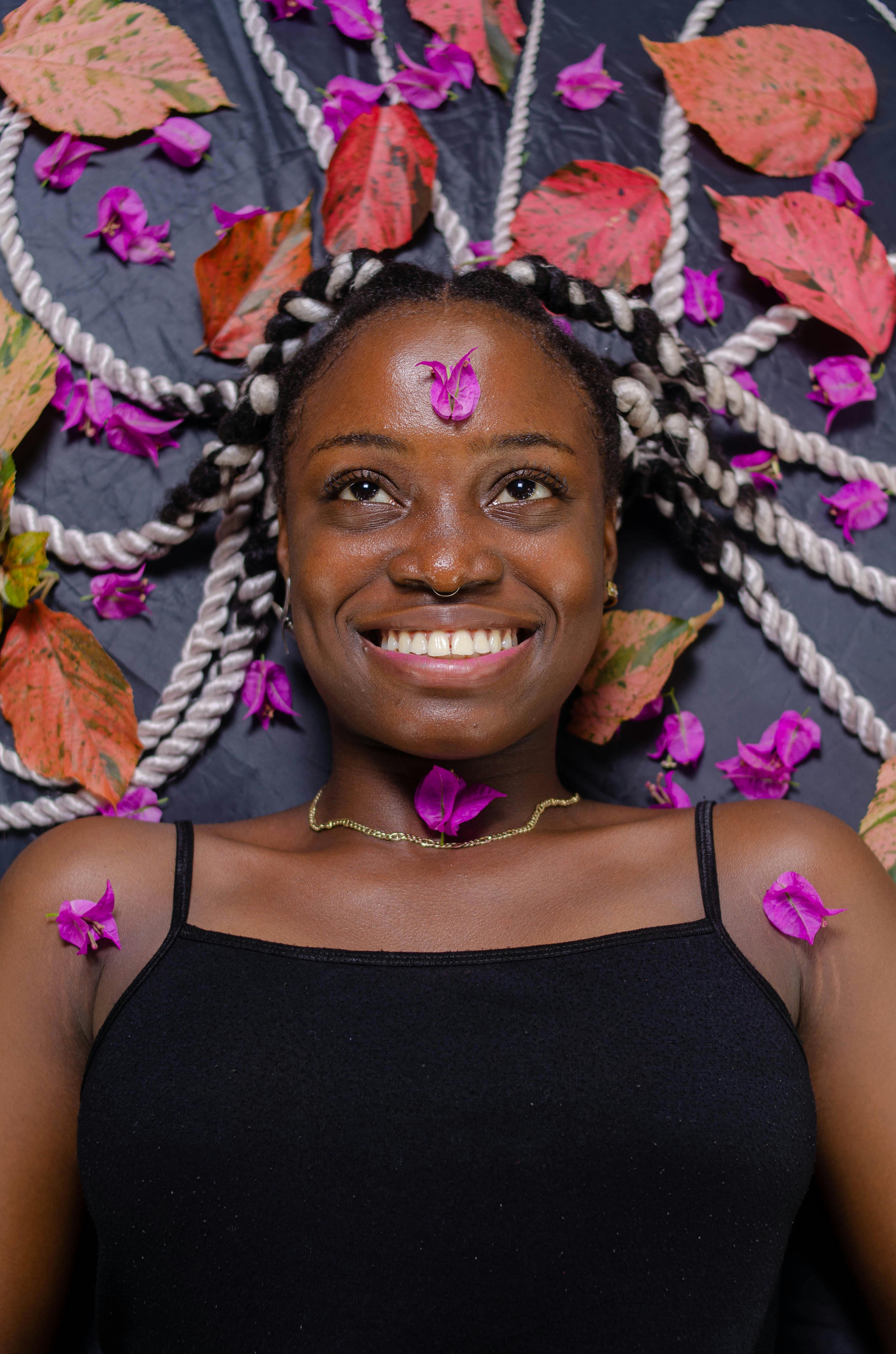 Smiling Woman with Dreadlocks and Flowers · Free Stock Photo