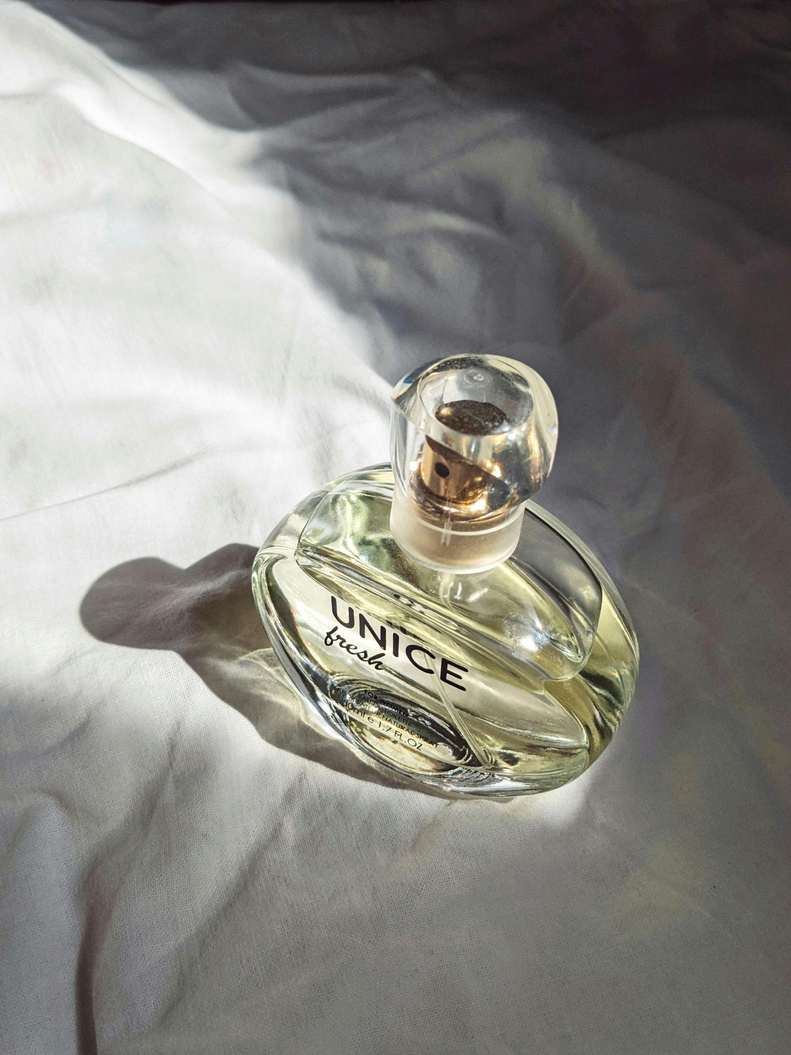 Perfume Bottle on Bedding · Free Stock Photo