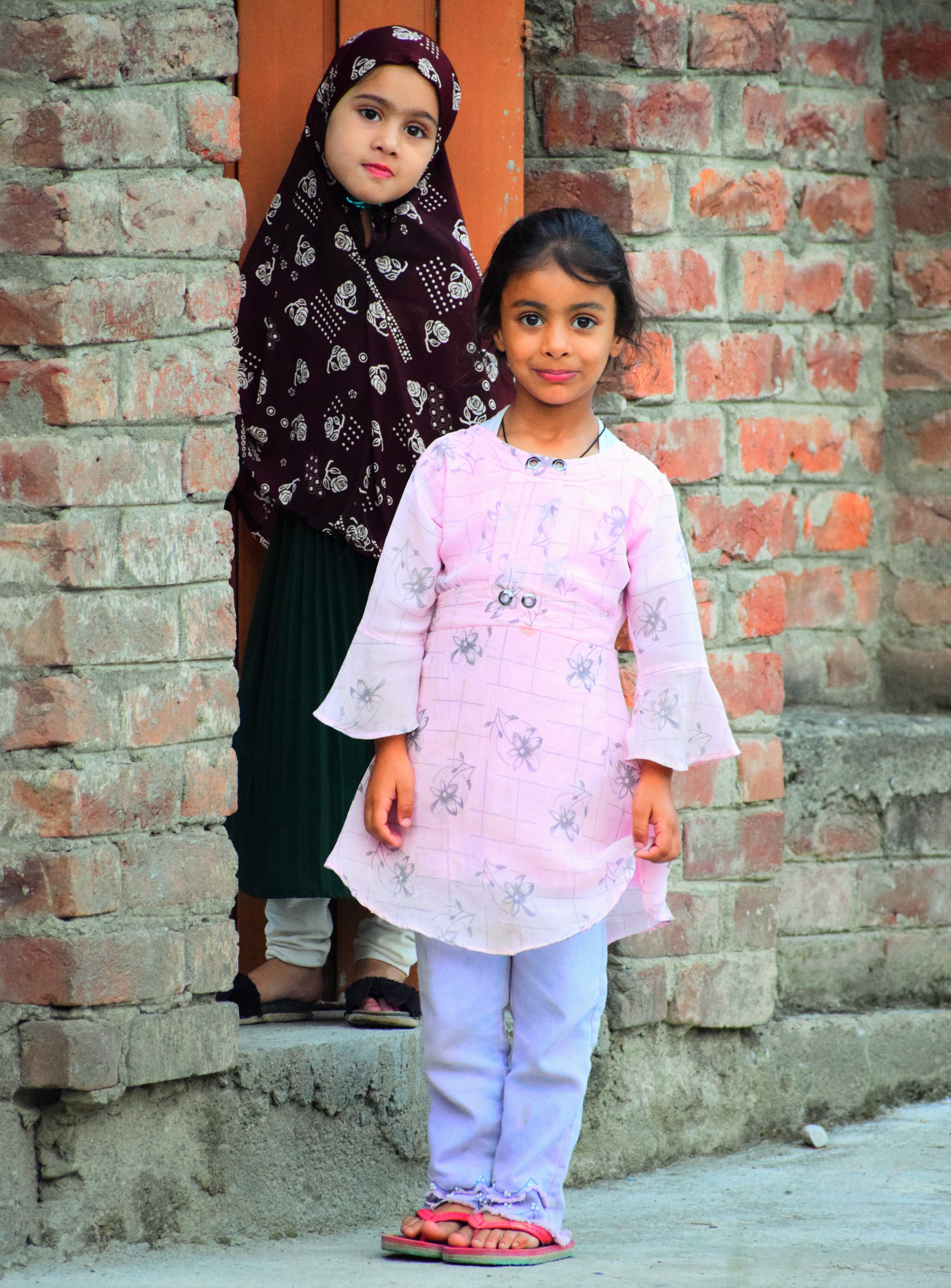 Girls in Traditional Clothing Standing by House Door · Free Stock Photo
