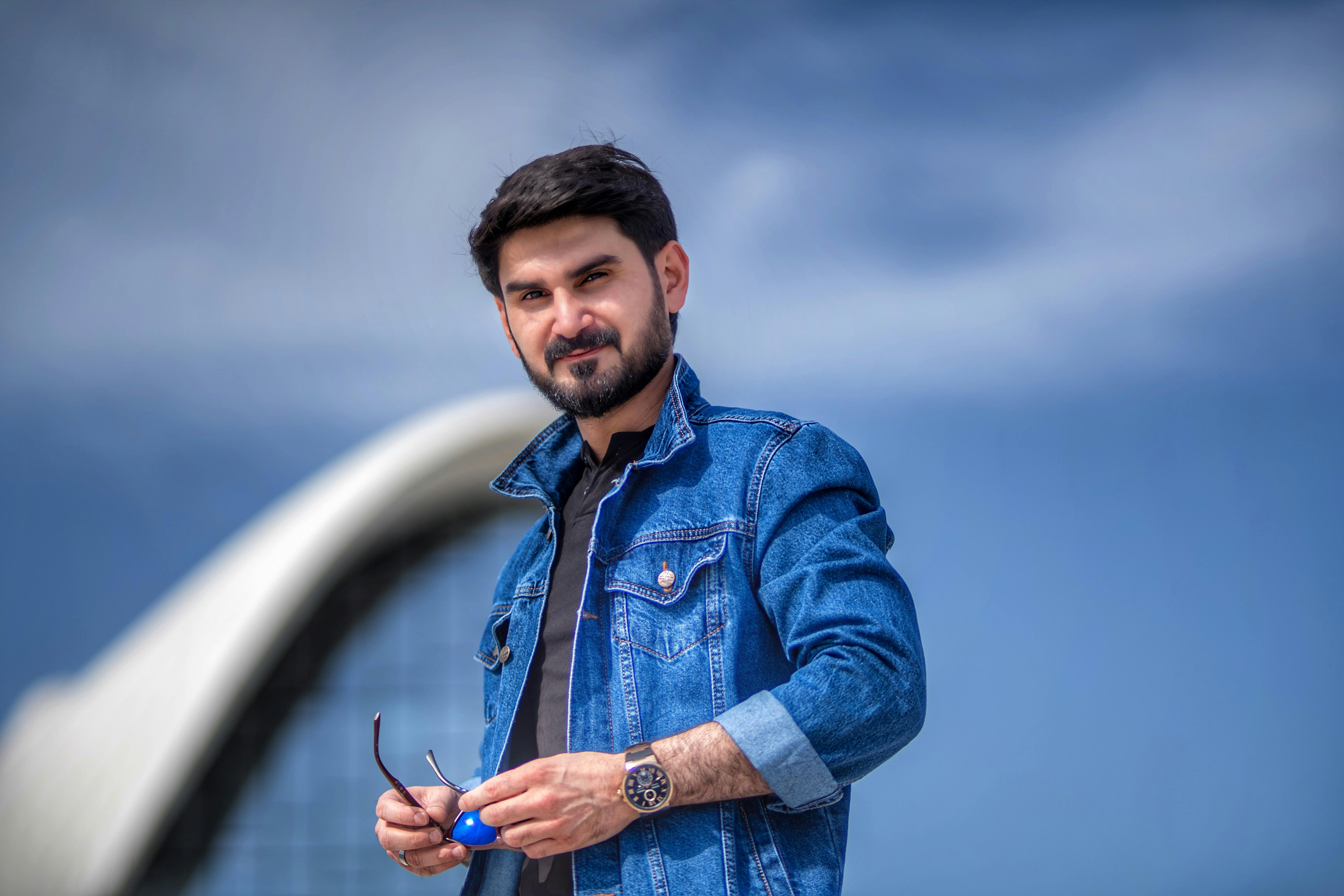 A Bearded Man in a Denim Jacket Standing Outside · Free Stock Photo