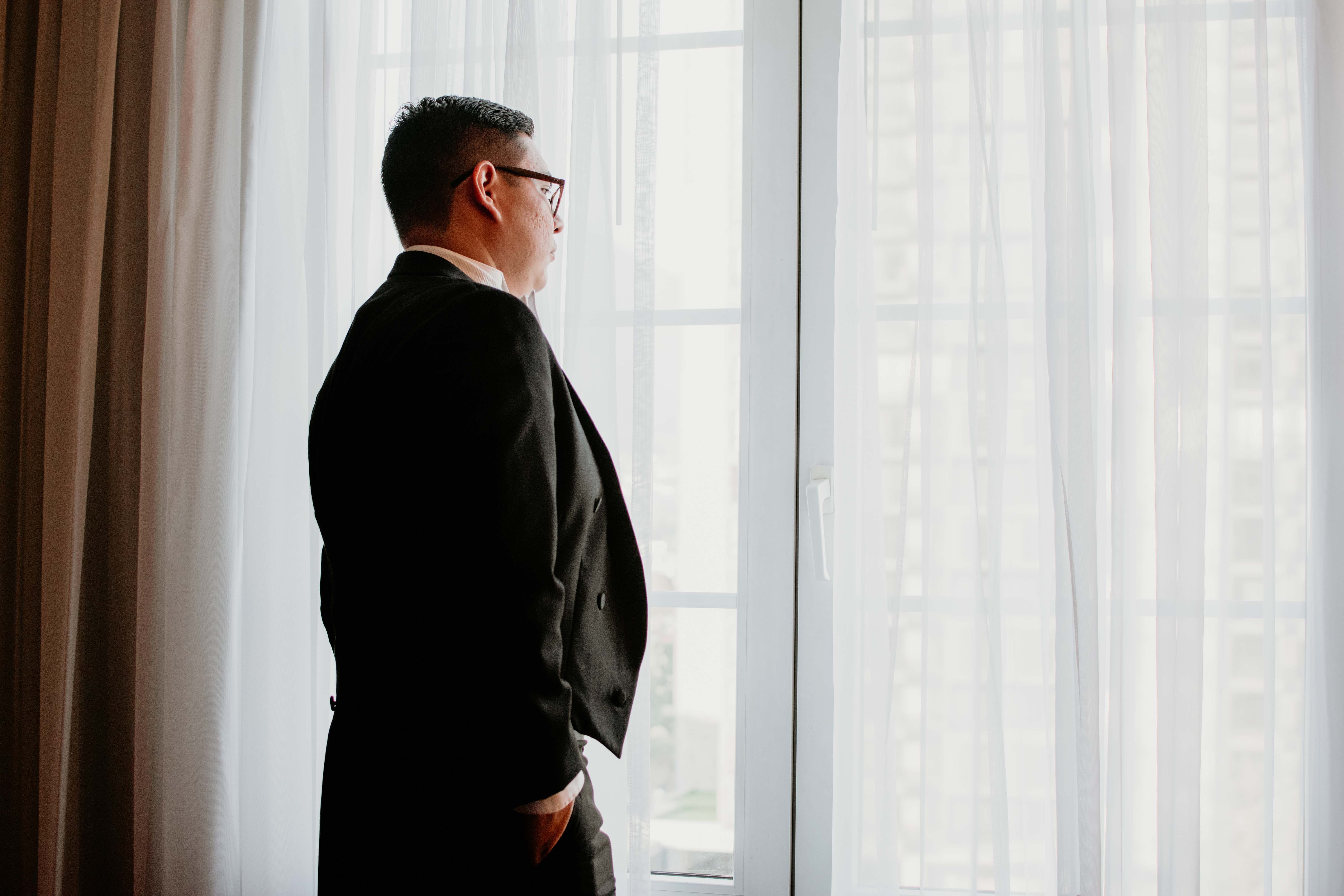 Elegant Man Standing by Window · Free Stock Photo