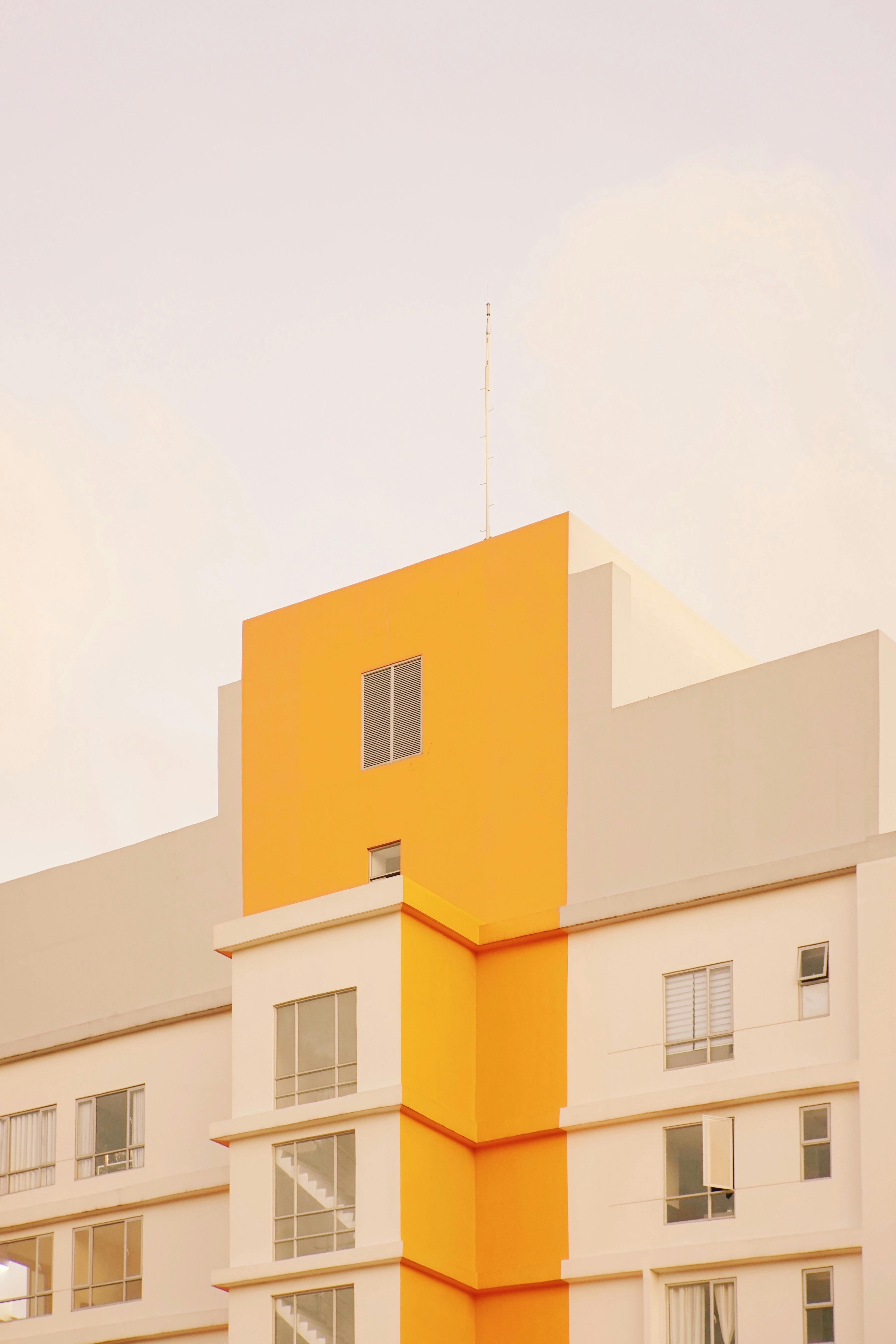 Low-angle Photography of Orange Concrete Building Under Blue and White ...