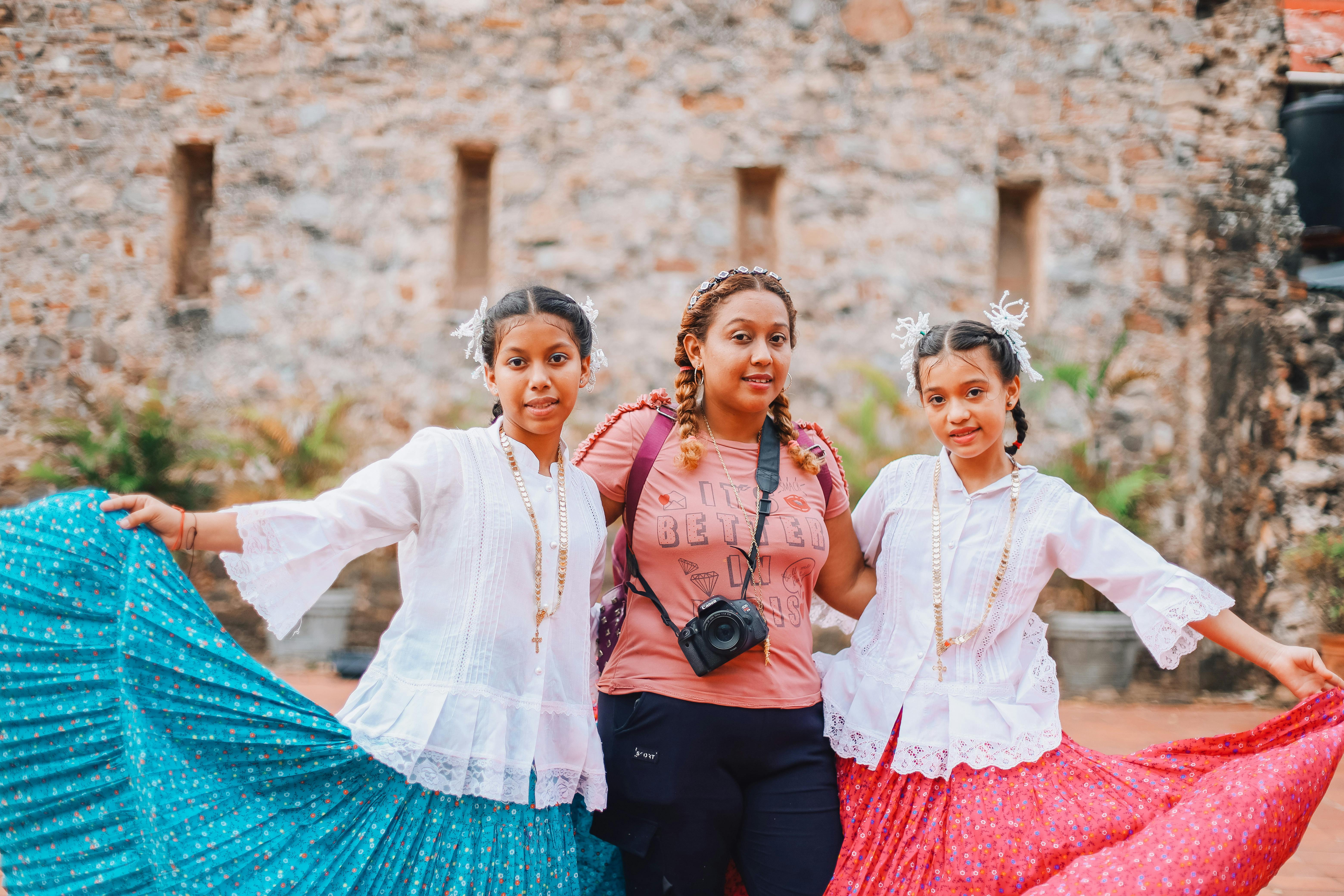 Women in Traditional Dress Stands with Photographer · Free Stock Photo