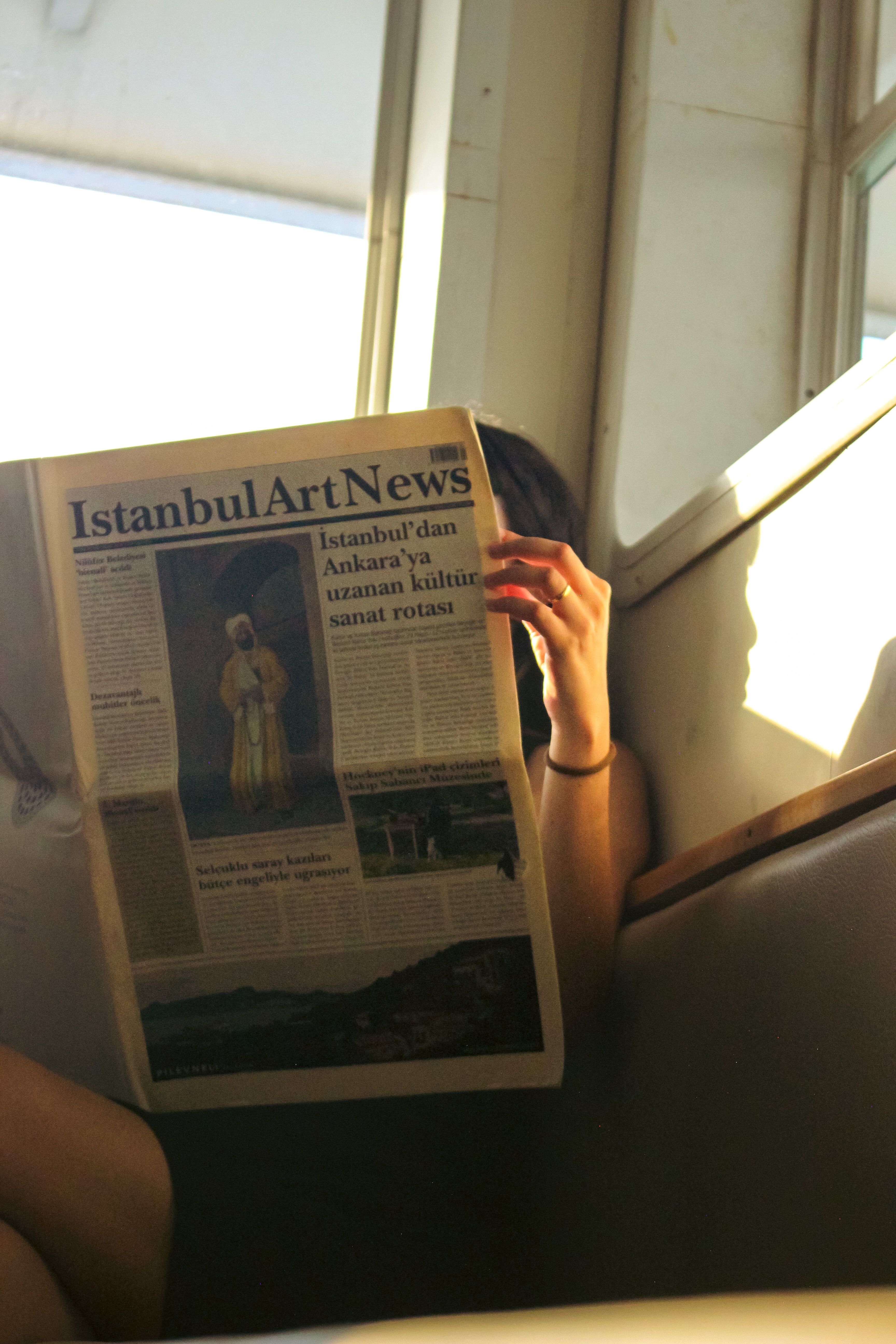 Brunette Woman in Dress Reading Newspaper on Ferry · Free Stock Photo