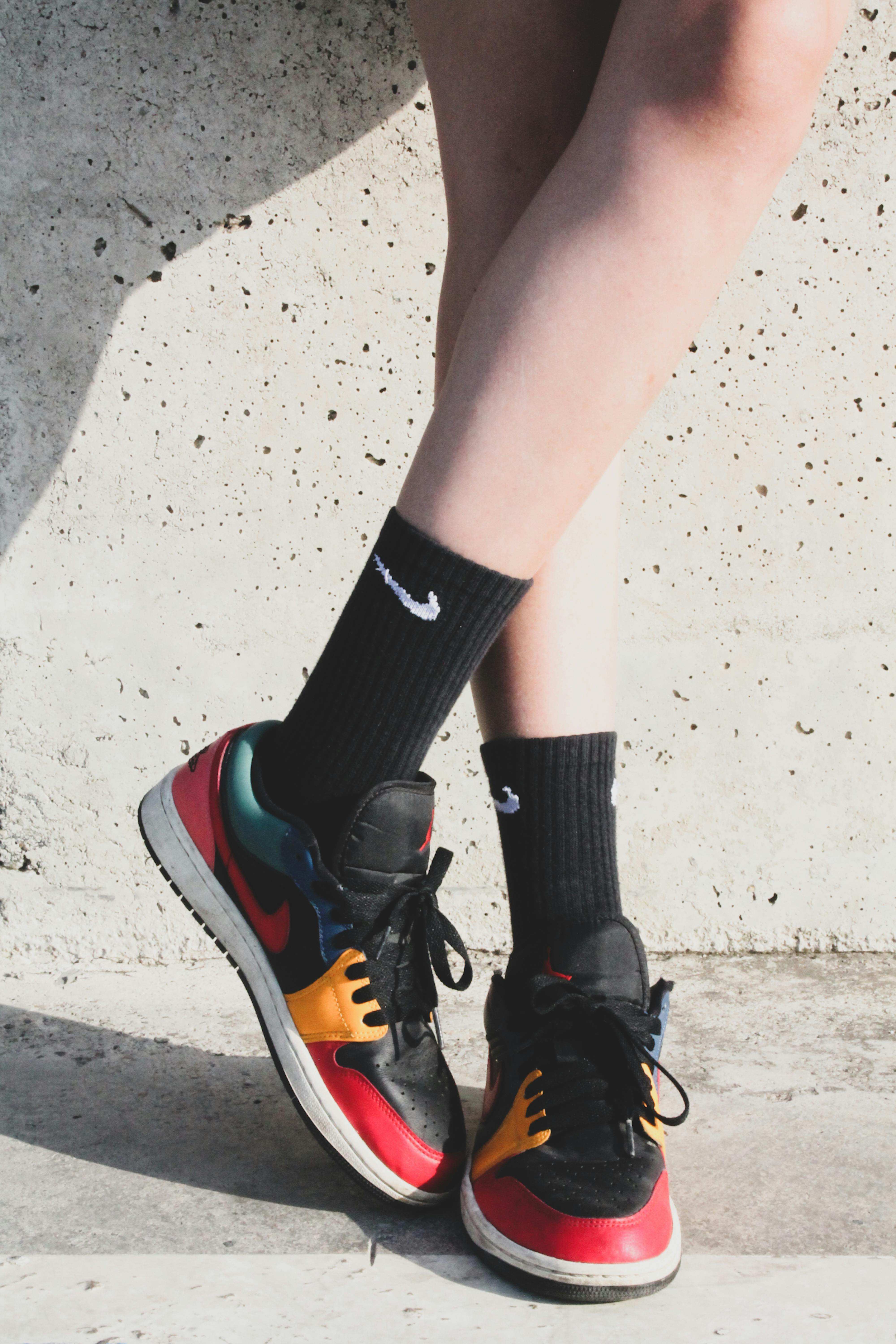 Multi Colored Trainers and Black Stock on Legs · Free Stock Photo