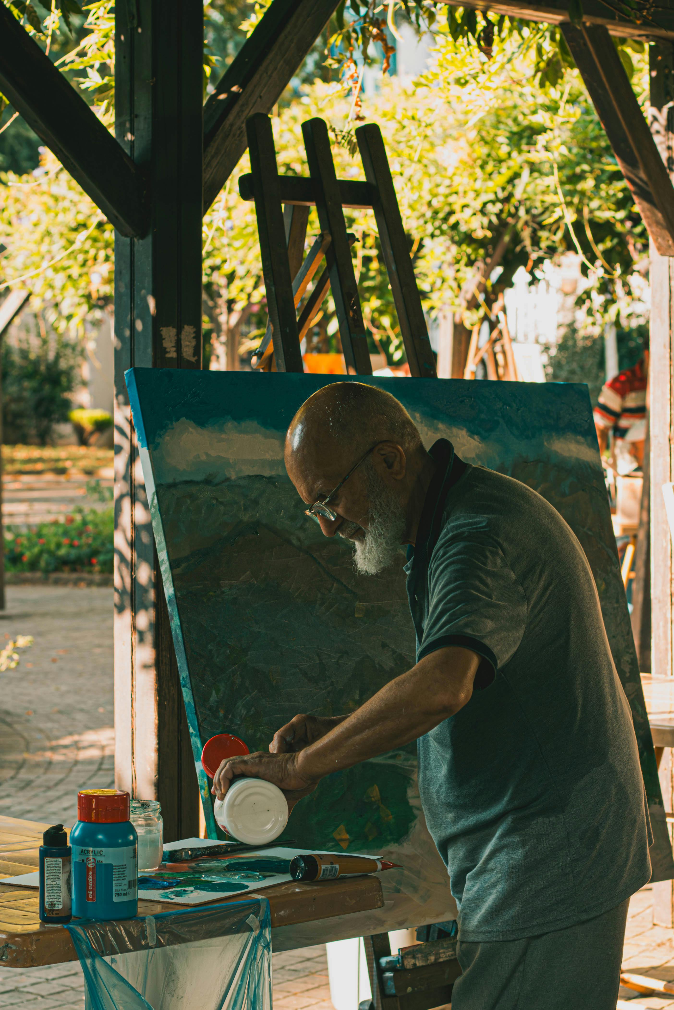 A man painting a picture on a canvas · Free Stock Photo