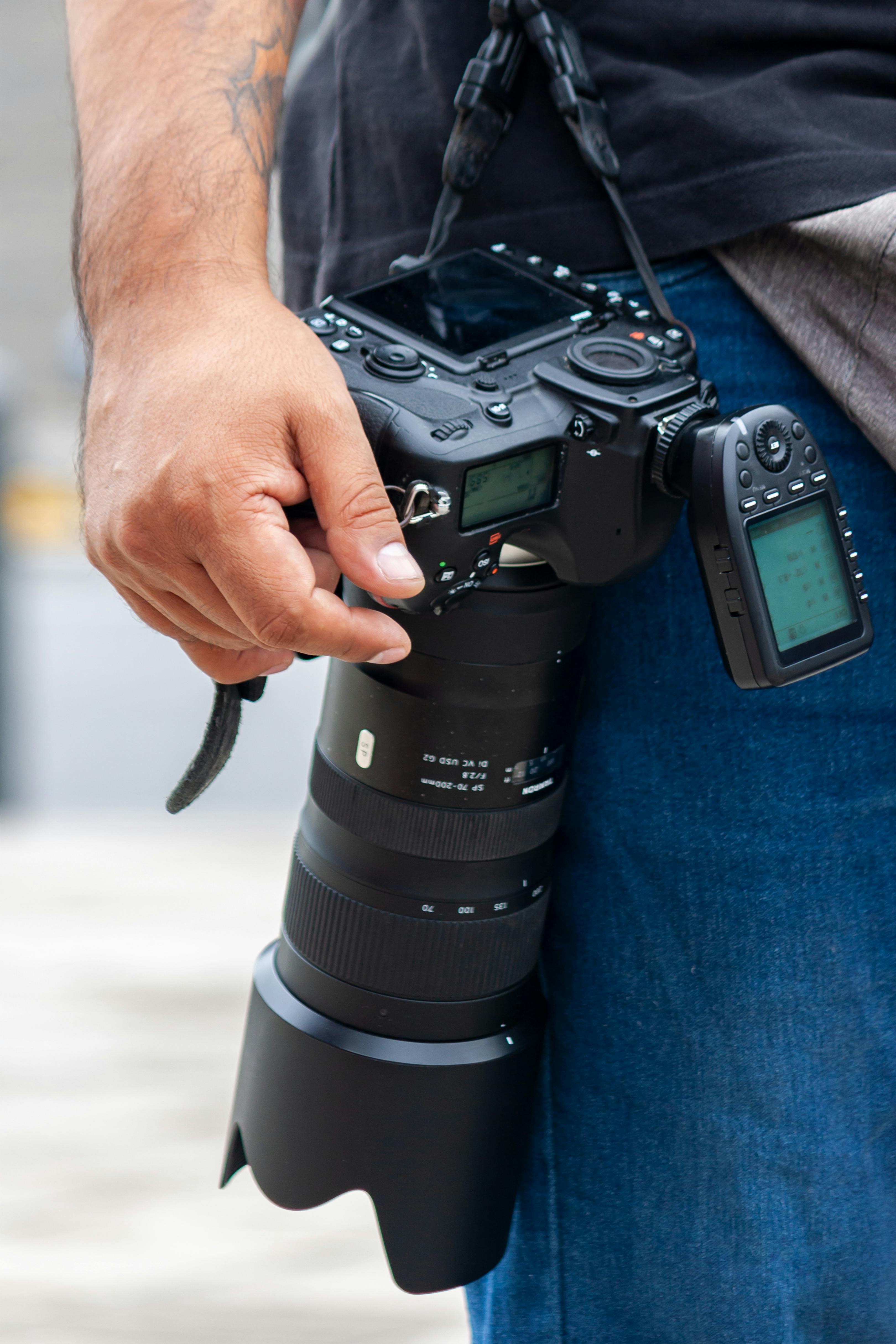 Free Close-up of a photographer holding a professional DSLR camera with ...