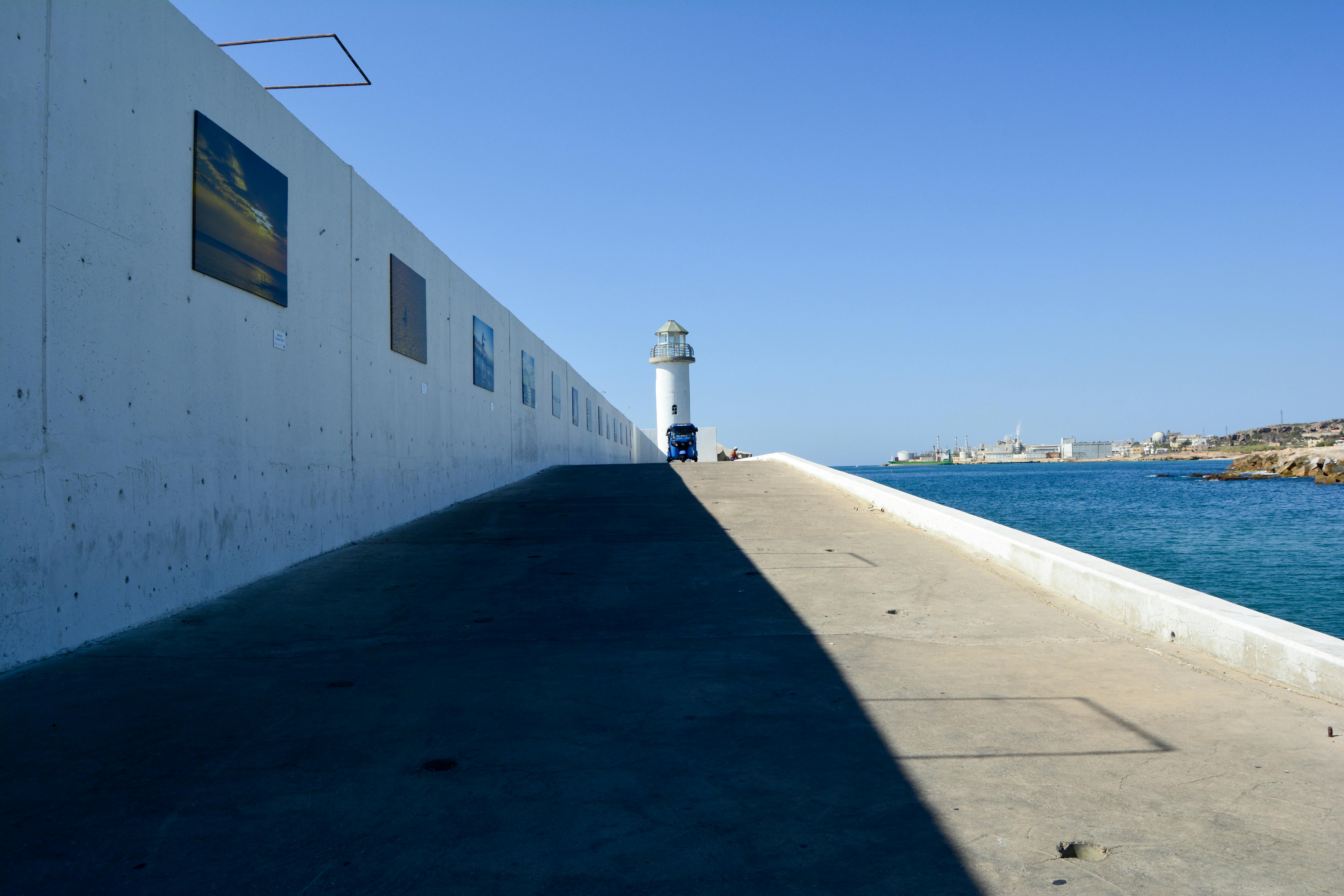 Rock and Mud on Sea Shore with Lighthouse behind at Sunset · Free Stock ...