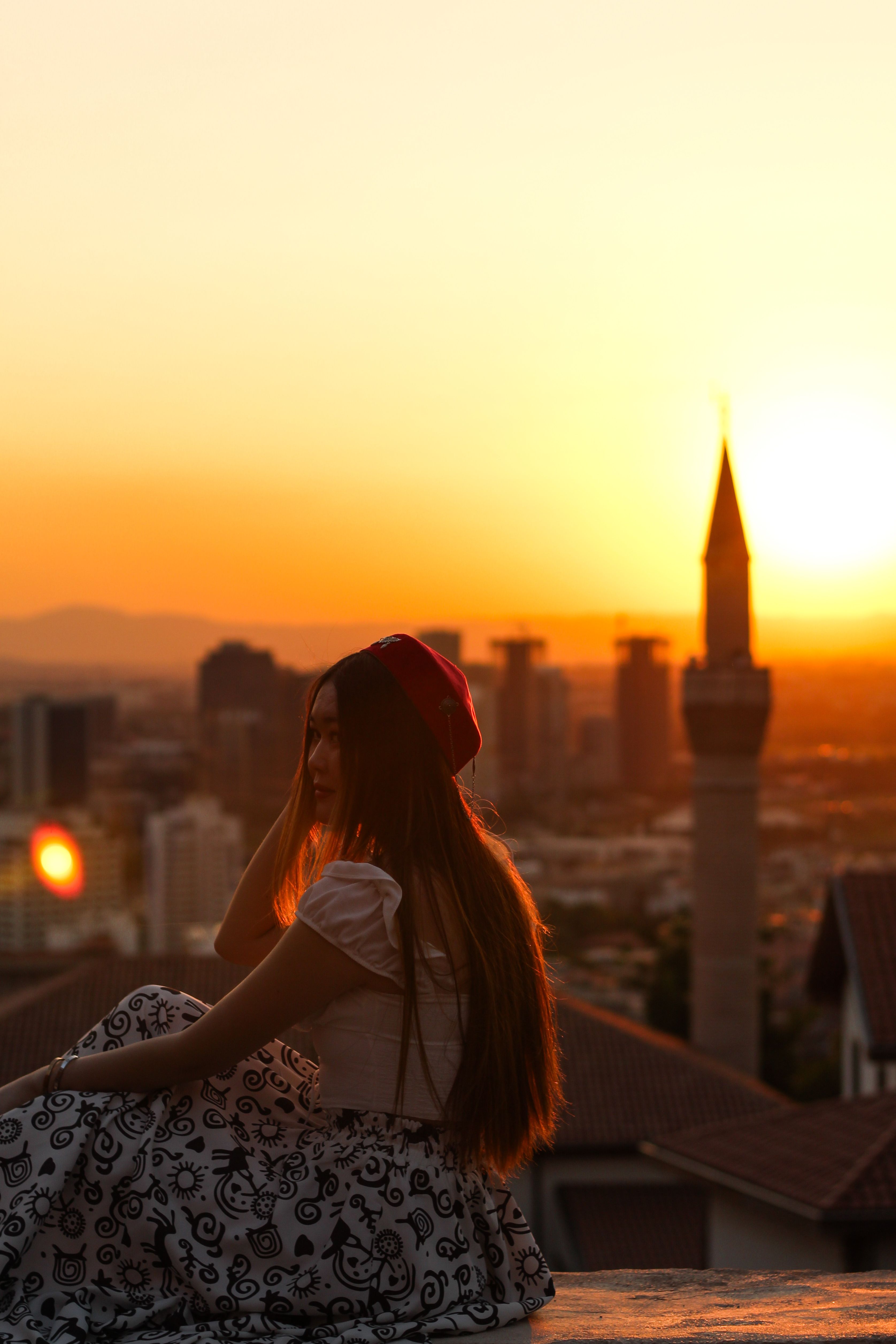 Woman in Sundress Sitting and Posing at Sunset · Free Stock Photo