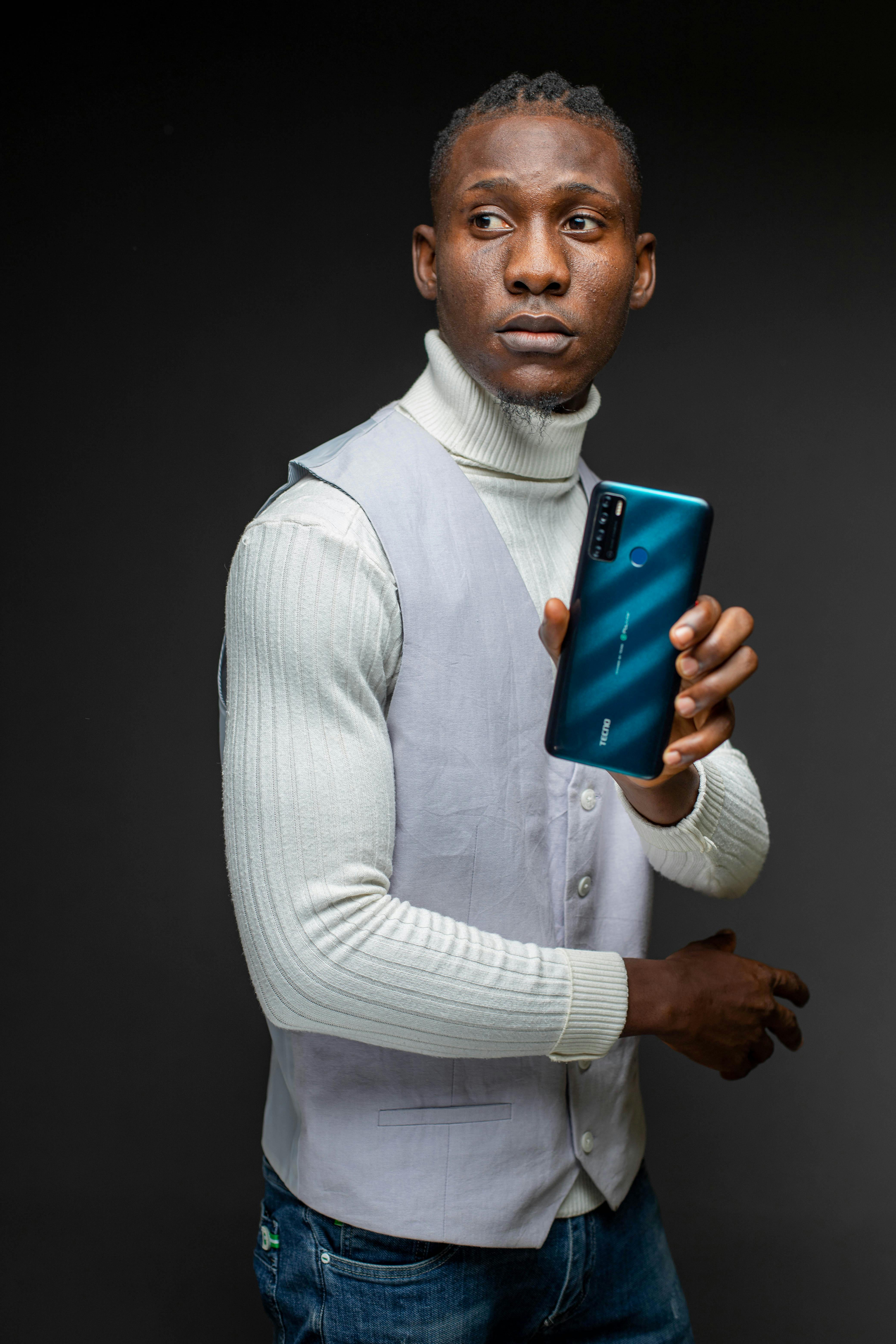Man in White Turtleneck Presenting Blue Smartphone · Free Stock Photo
