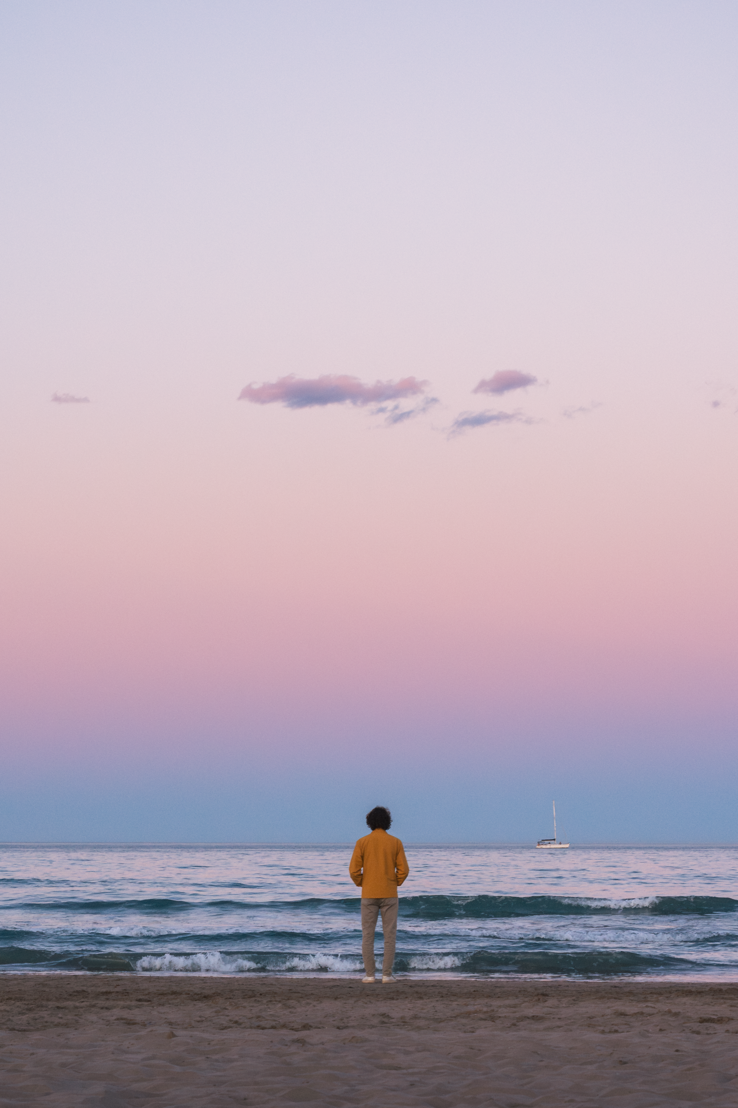 Man Standing on a Beach at Dusk · Free Stock Photo