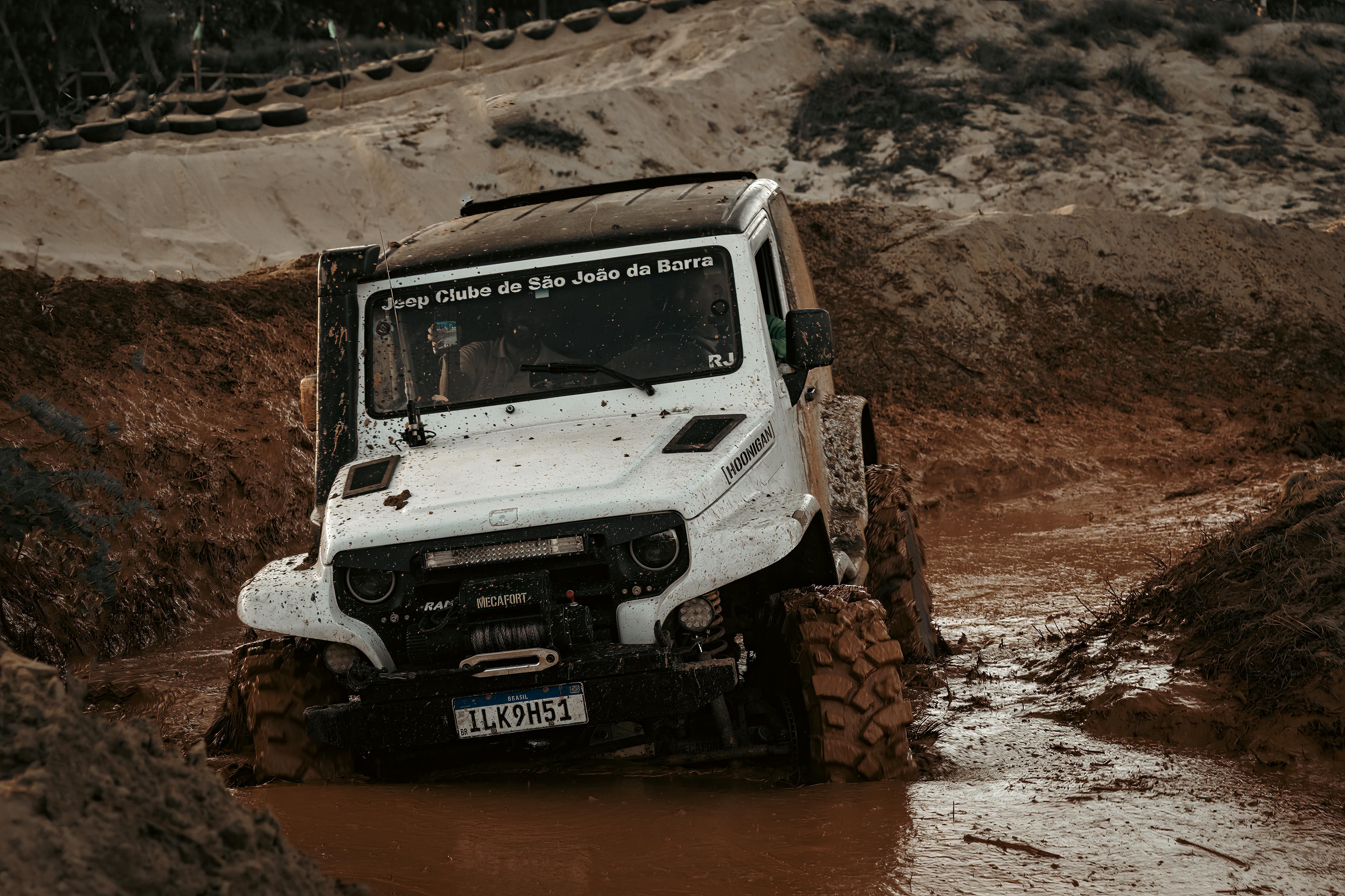 Off-Road Vehicle Wading in a Muddy Ditch with Water · Free Stock Photo