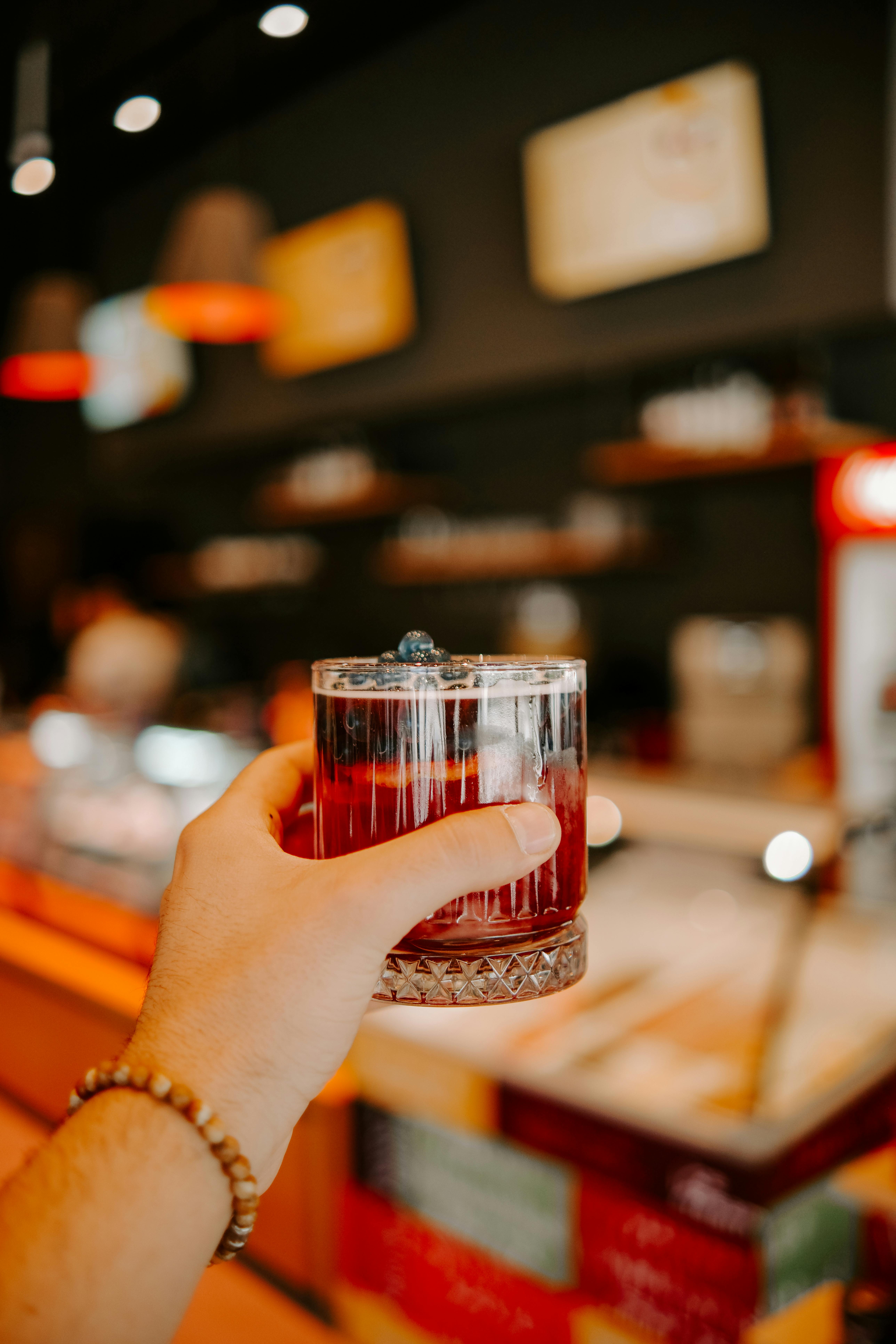 Holding a Glass of Red Soda with Fruits · Free Stock Photo