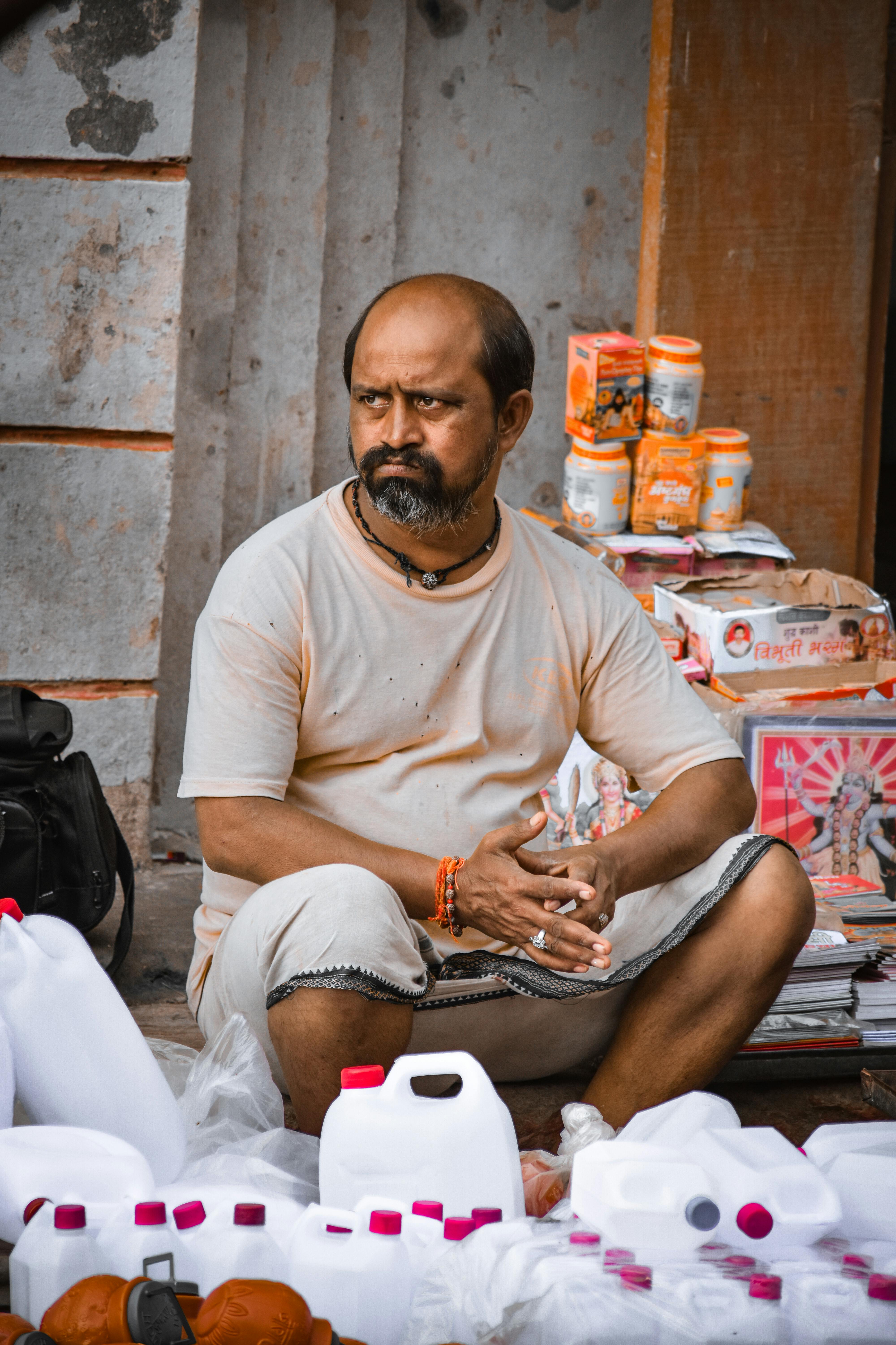 Merchant Sitting among his Merchandise · Free Stock Photo
