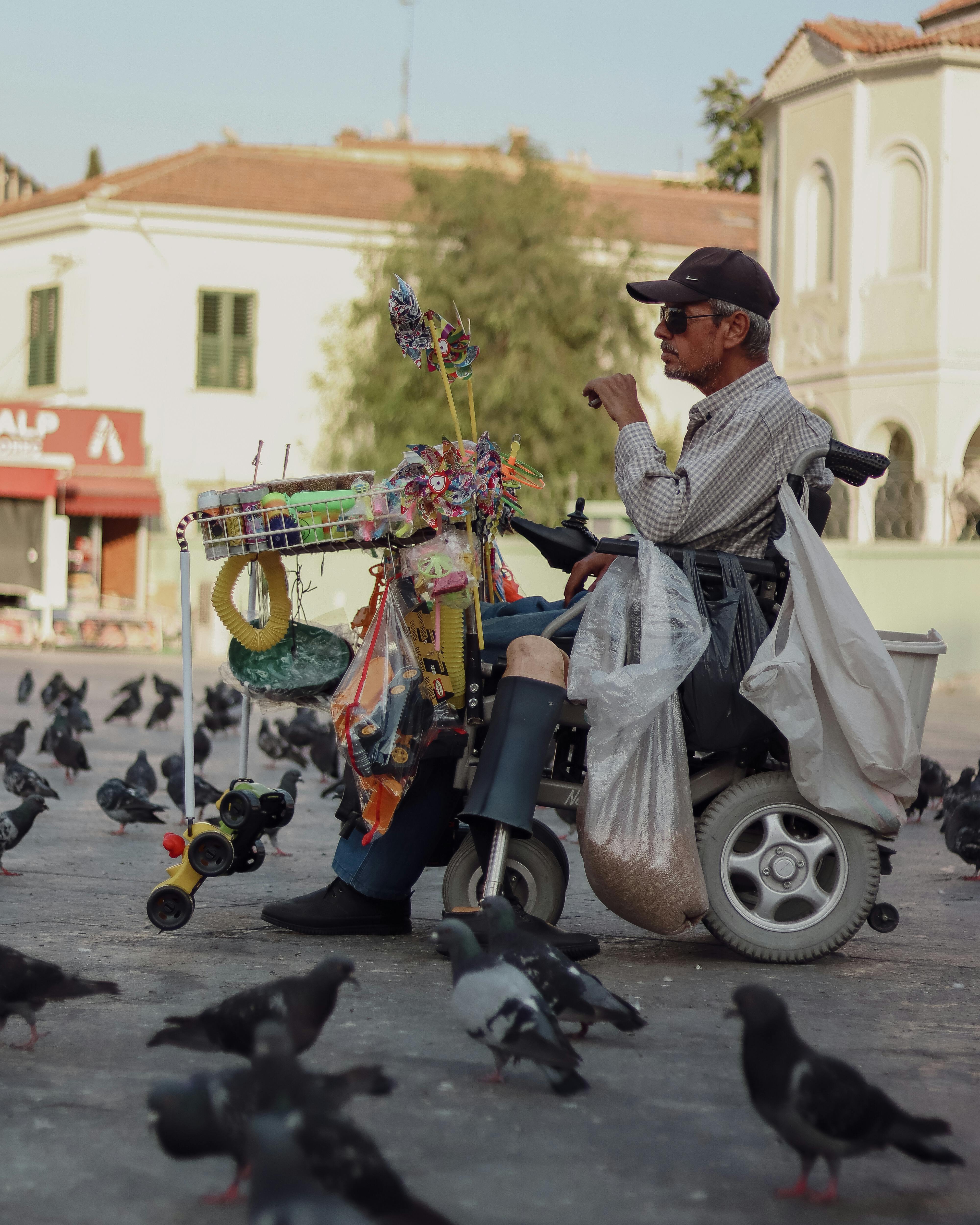 Birds around Street Vendor on Wheelchair on Square in Town · Free Stock ...