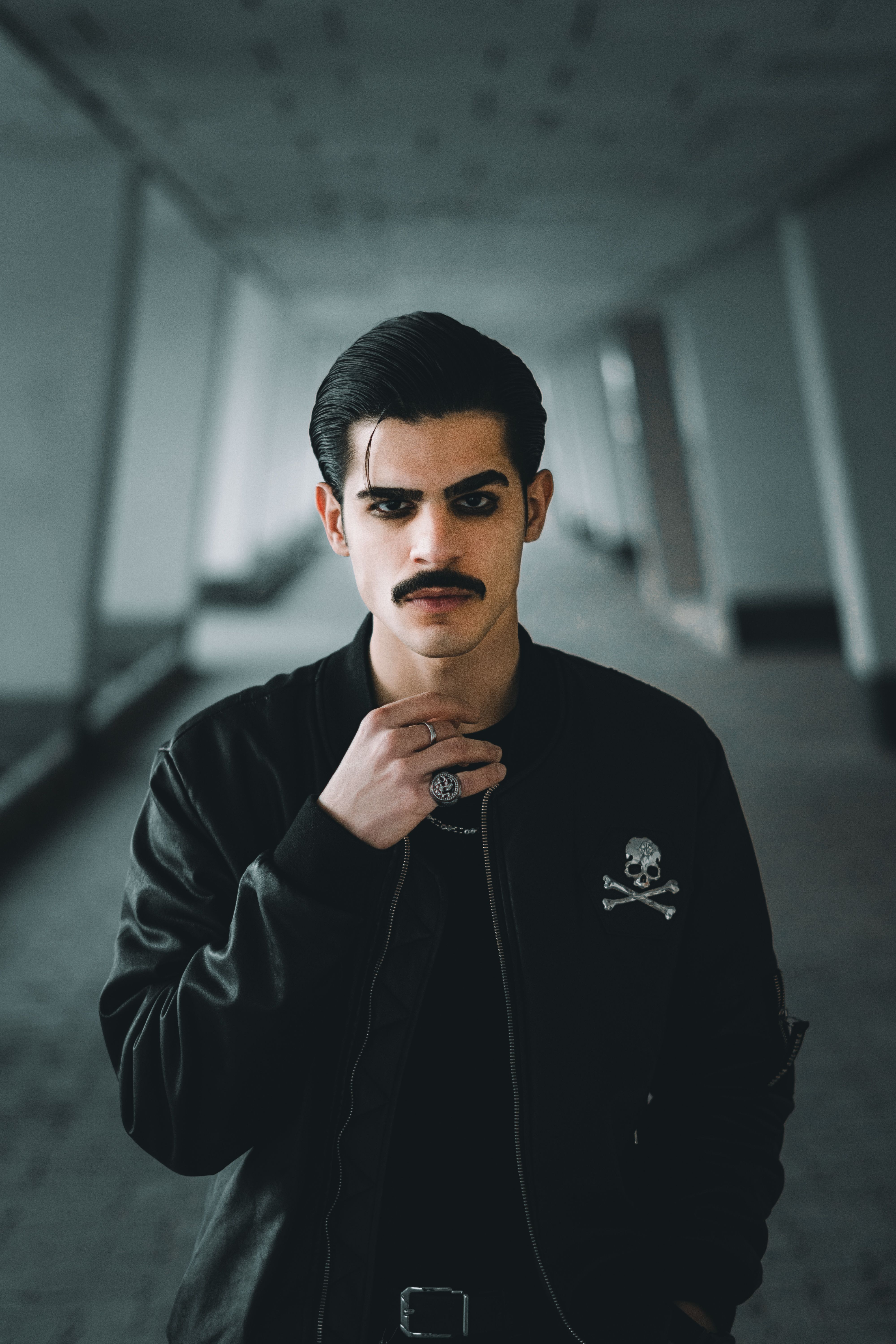 Young Man with Mustache and All Black Outfit Standing in a Hallway ...