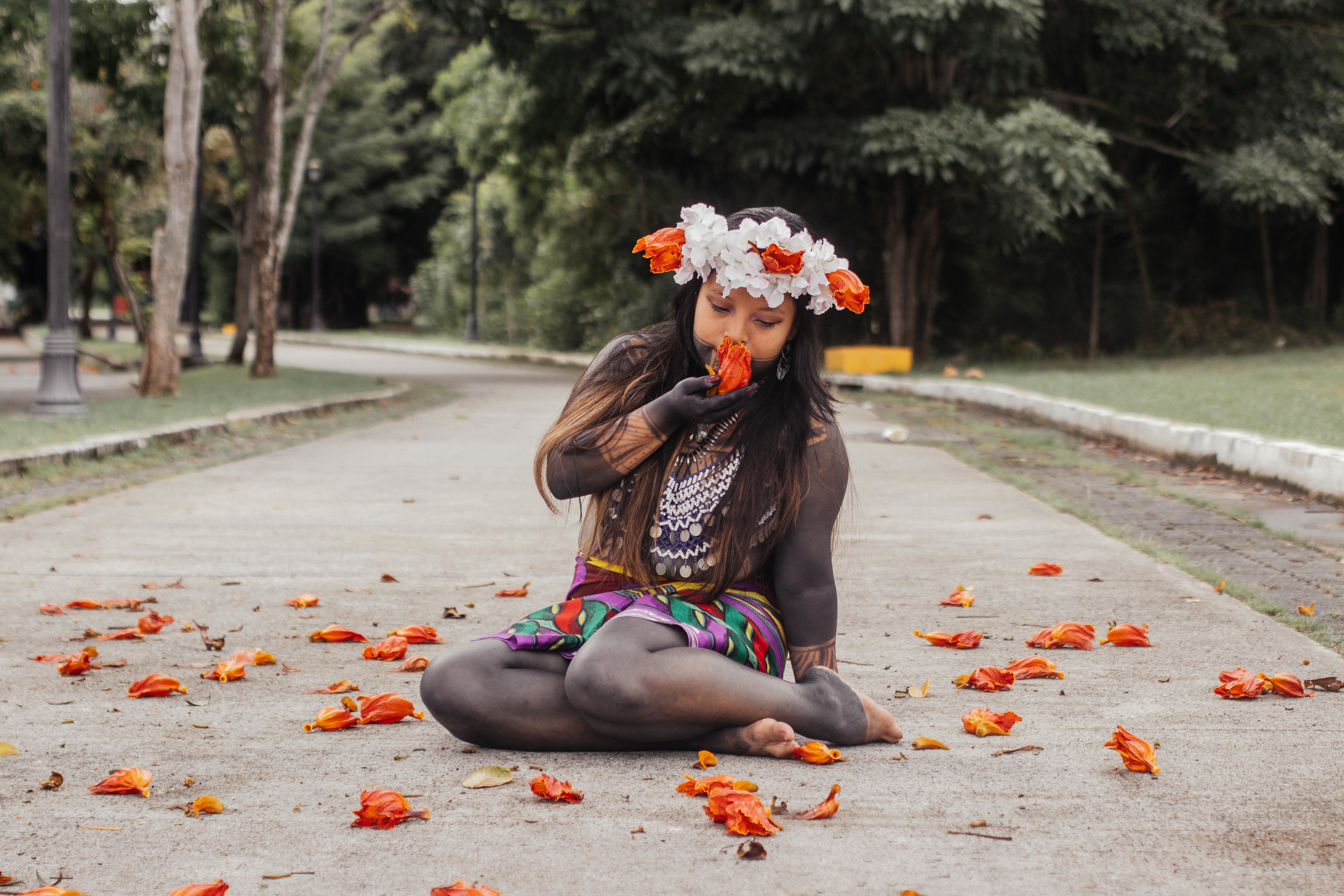Young Woman in a Traditional Costume and Body Painting Sitting on the Pavement · Free Stock Photo