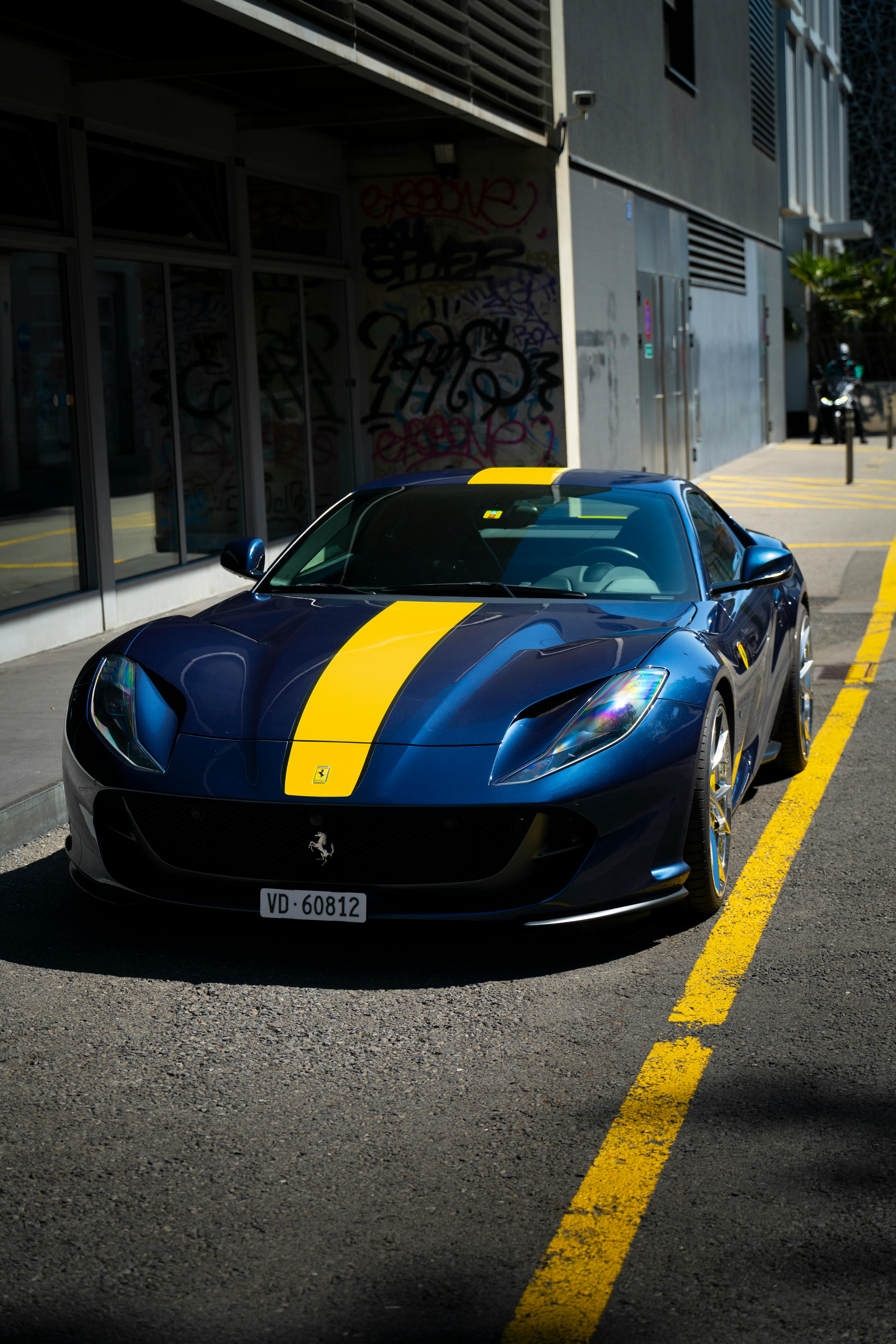 A blue sports car with yellow stripes parked on the street · Free Stock ...