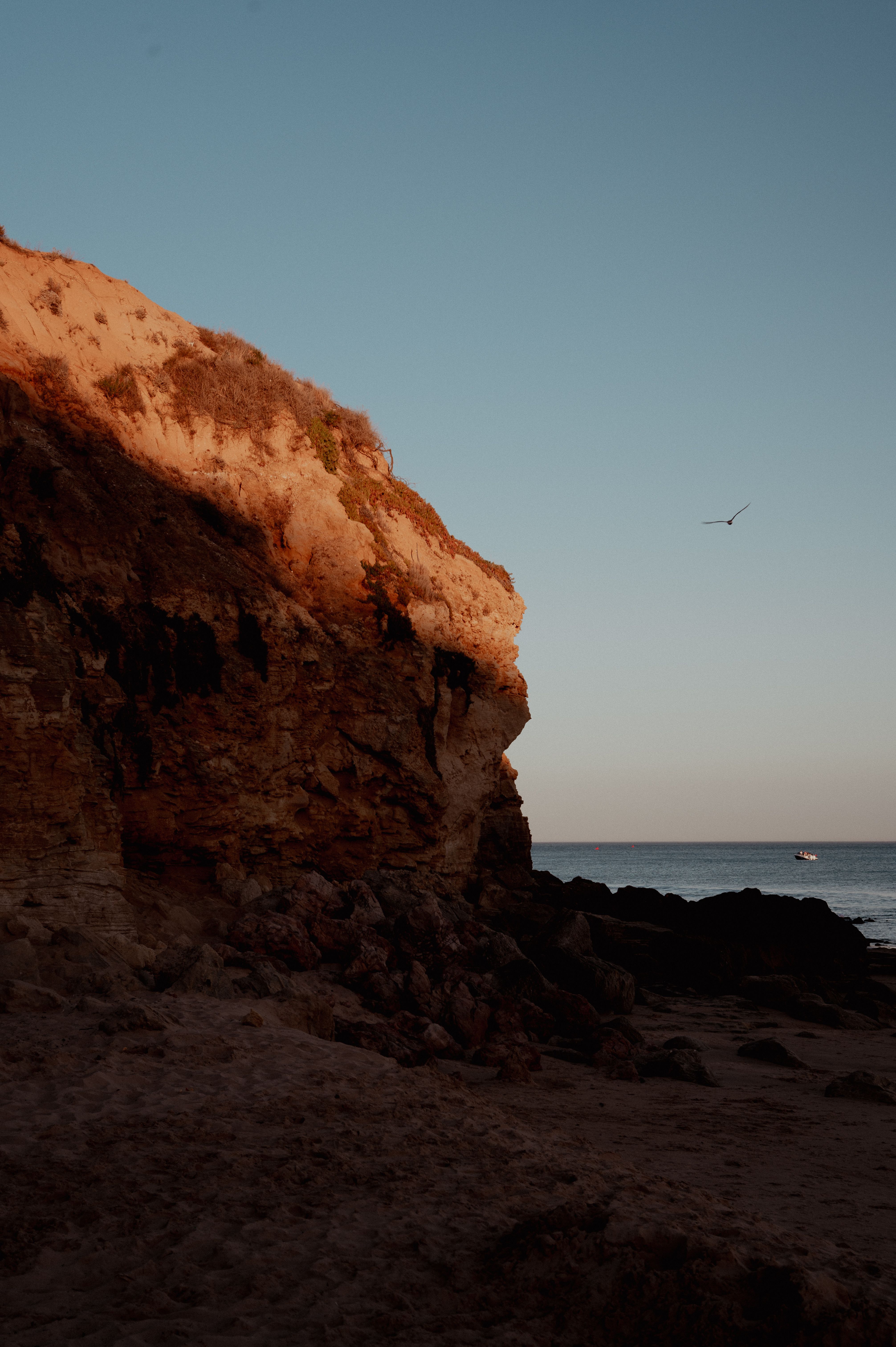 View of a Rocky Cliff on a Shore under a Clear Sky · Free Stock Photo