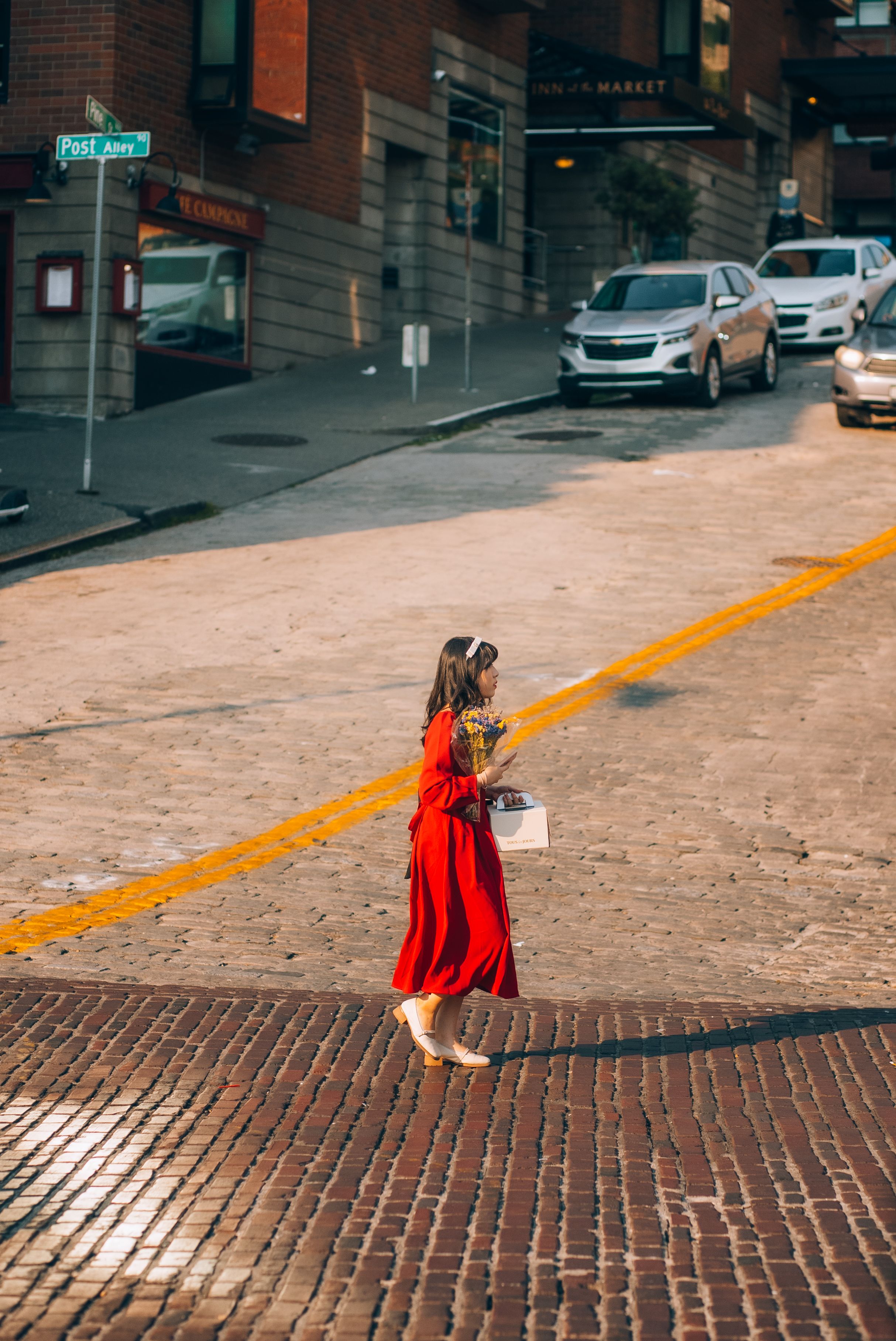 A woman in a red dress walking down a street · Free Stock Photo