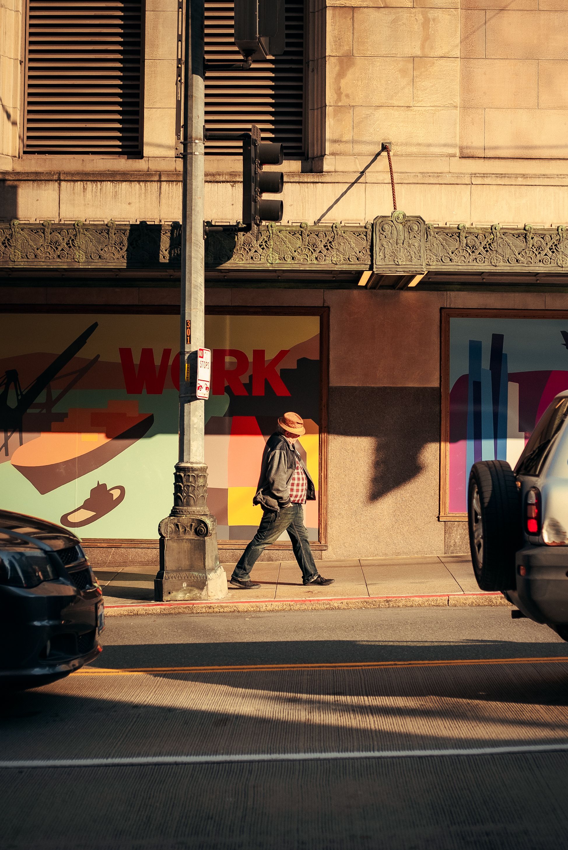 A man walking down the street in front of a building · Free Stock Photo