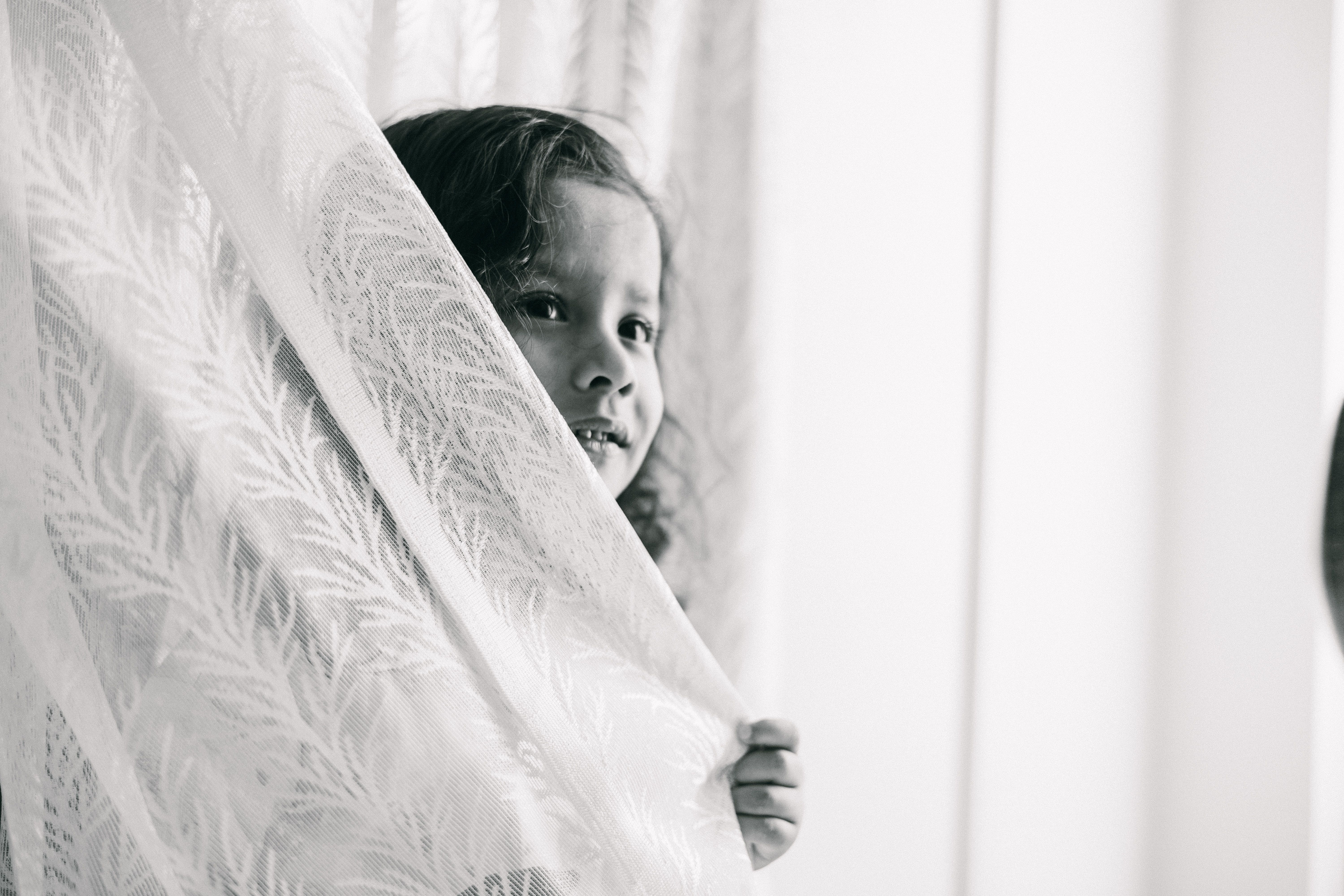 Young Girl Hiding Behind a Curtain · Free Stock Photo