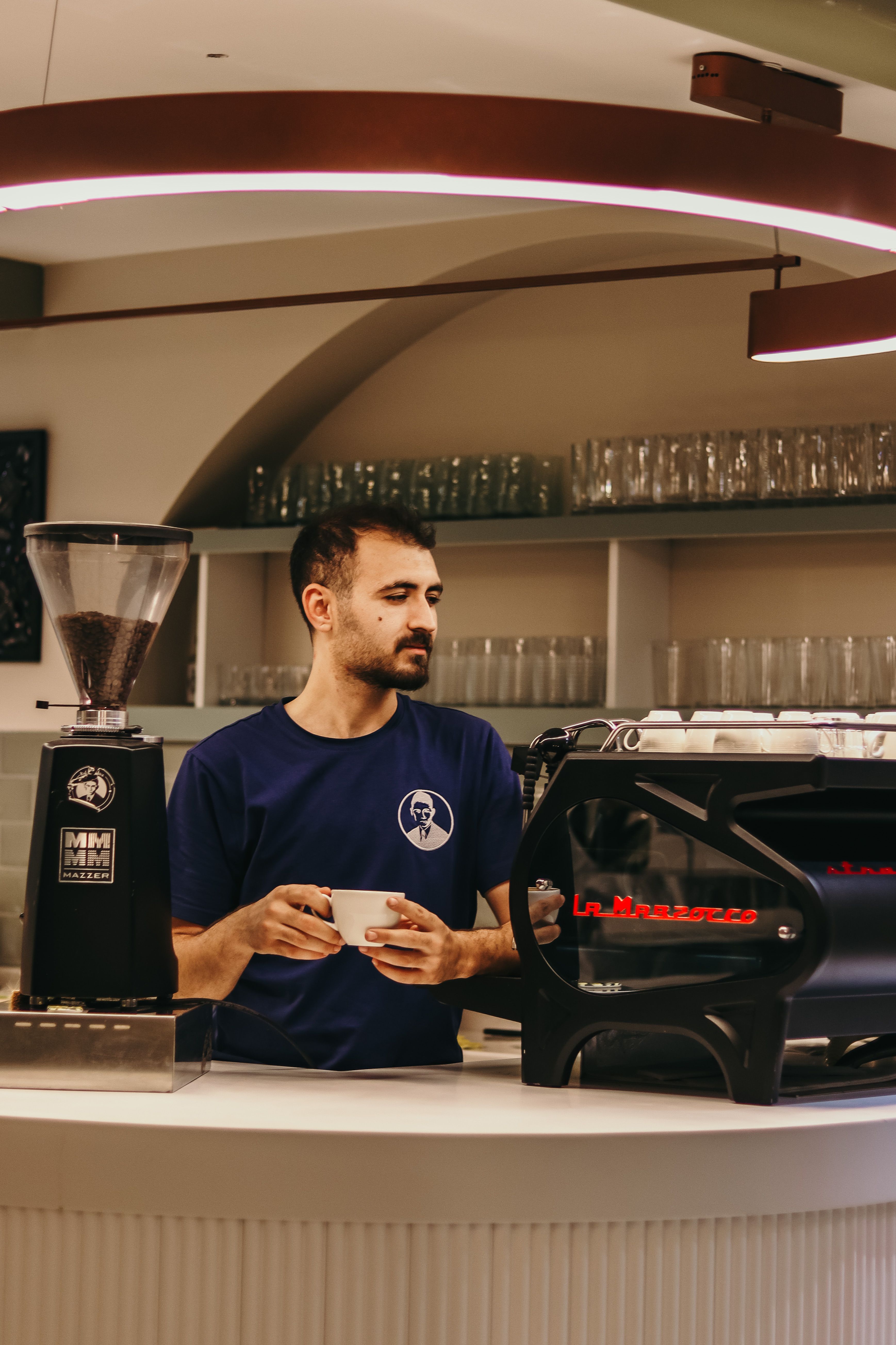 A Man Over the Counter with a Cup of Coffee · Free Stock Photo