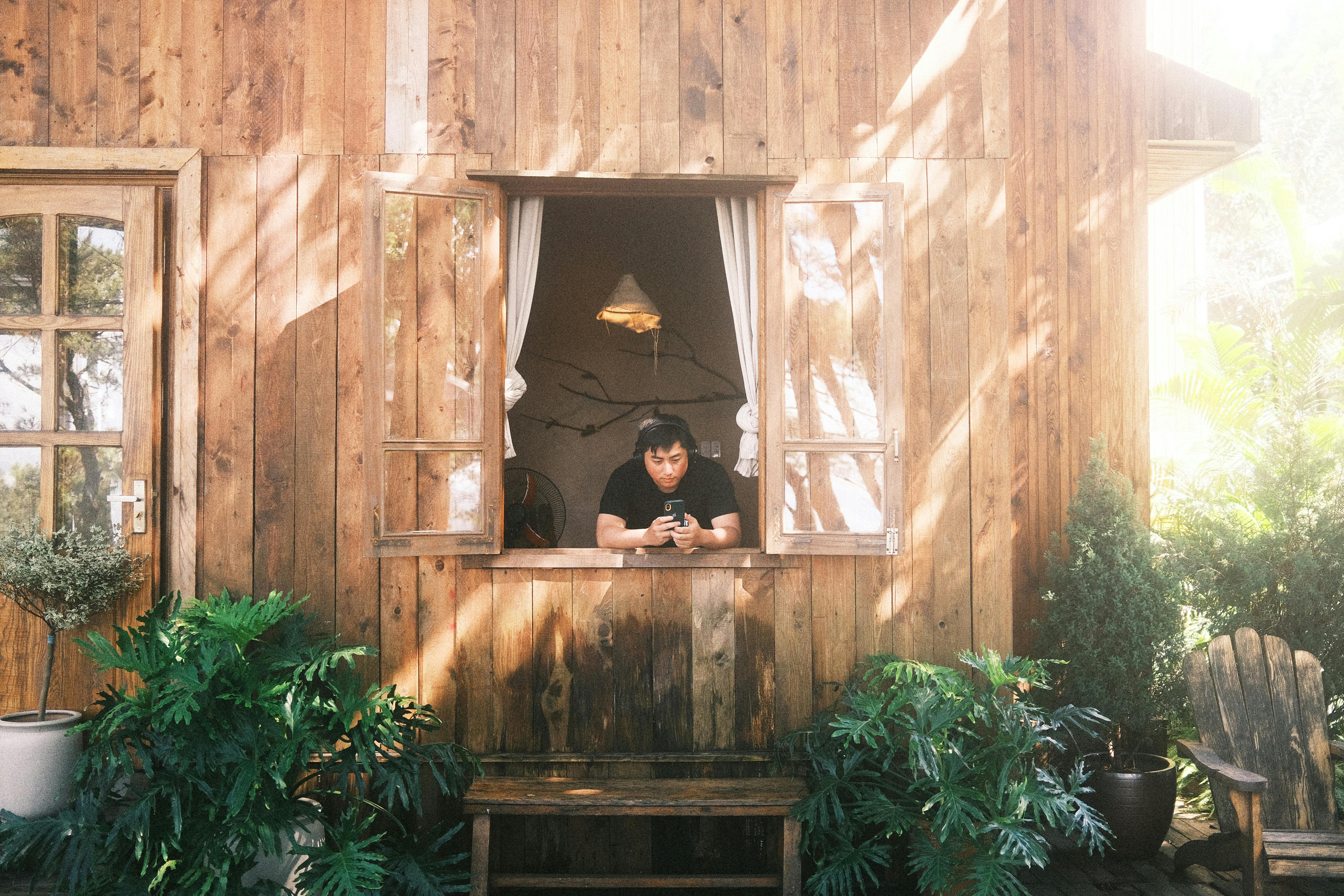 Man in a Window in a Wooden Hut · Free Stock Photo