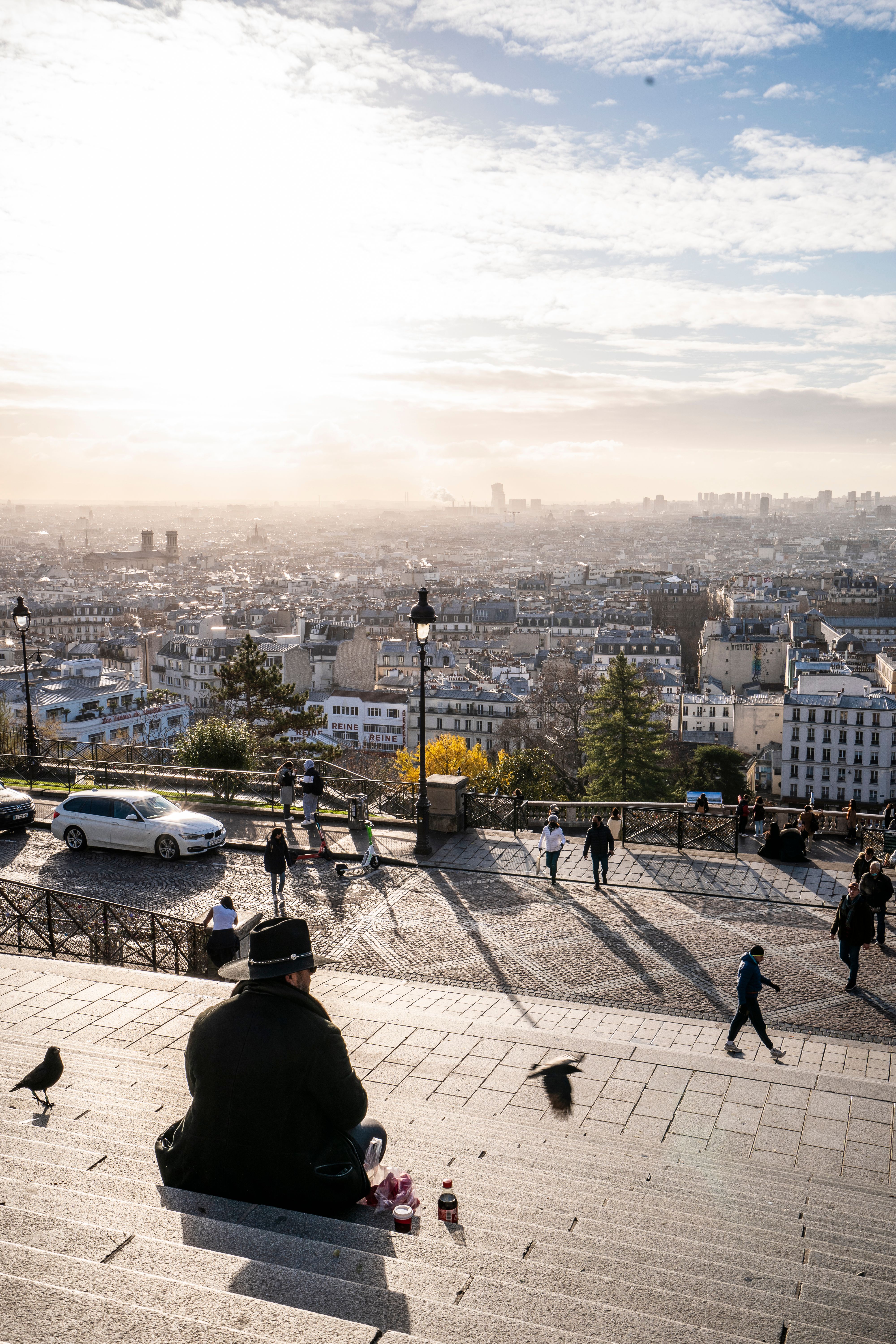 Back View of a Man Sitting on Steps with a Panoramic View of Paris, France · Free Stock Photo