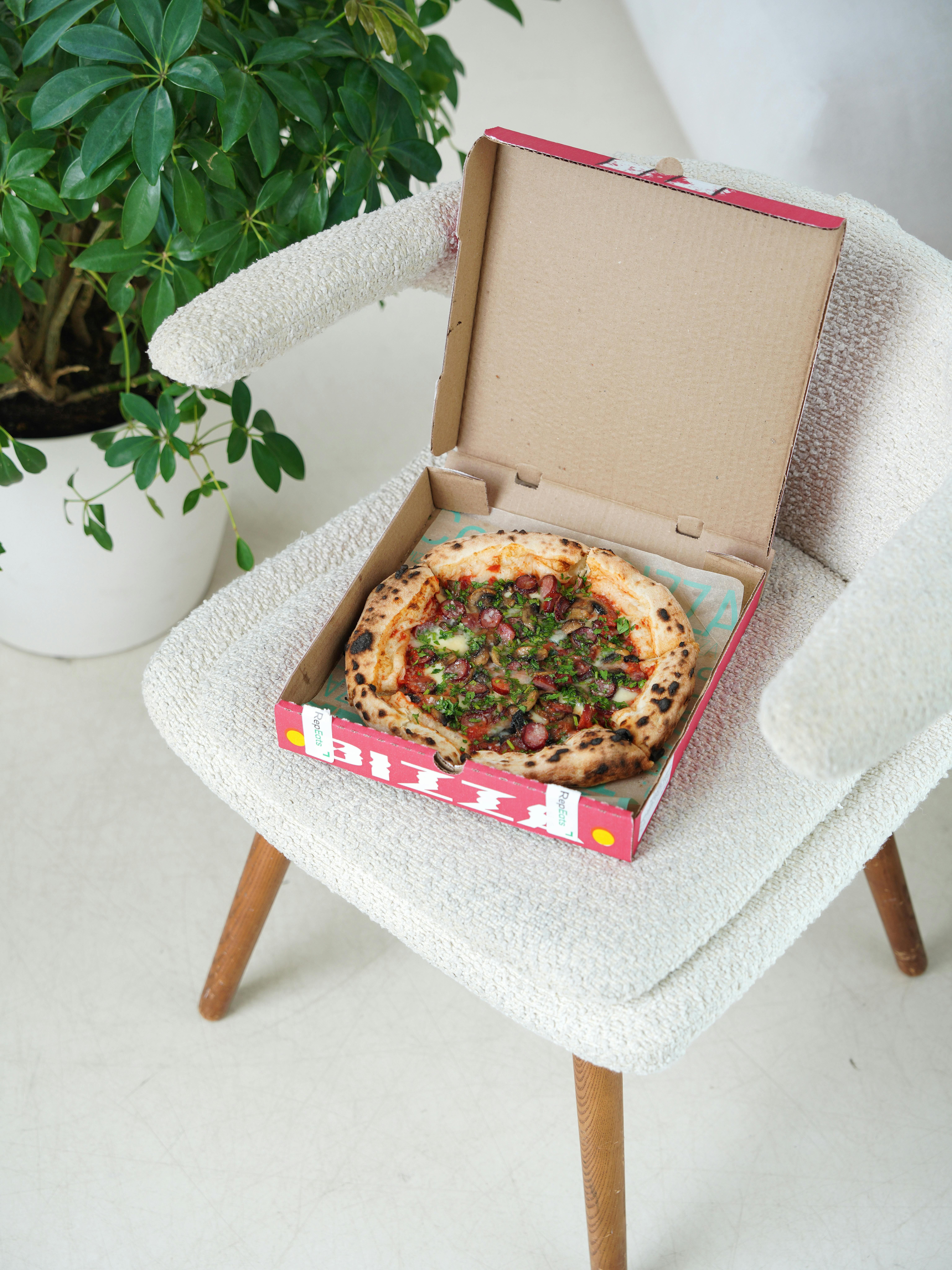 A Box with Pizza on a Chair · Free Stock Photo