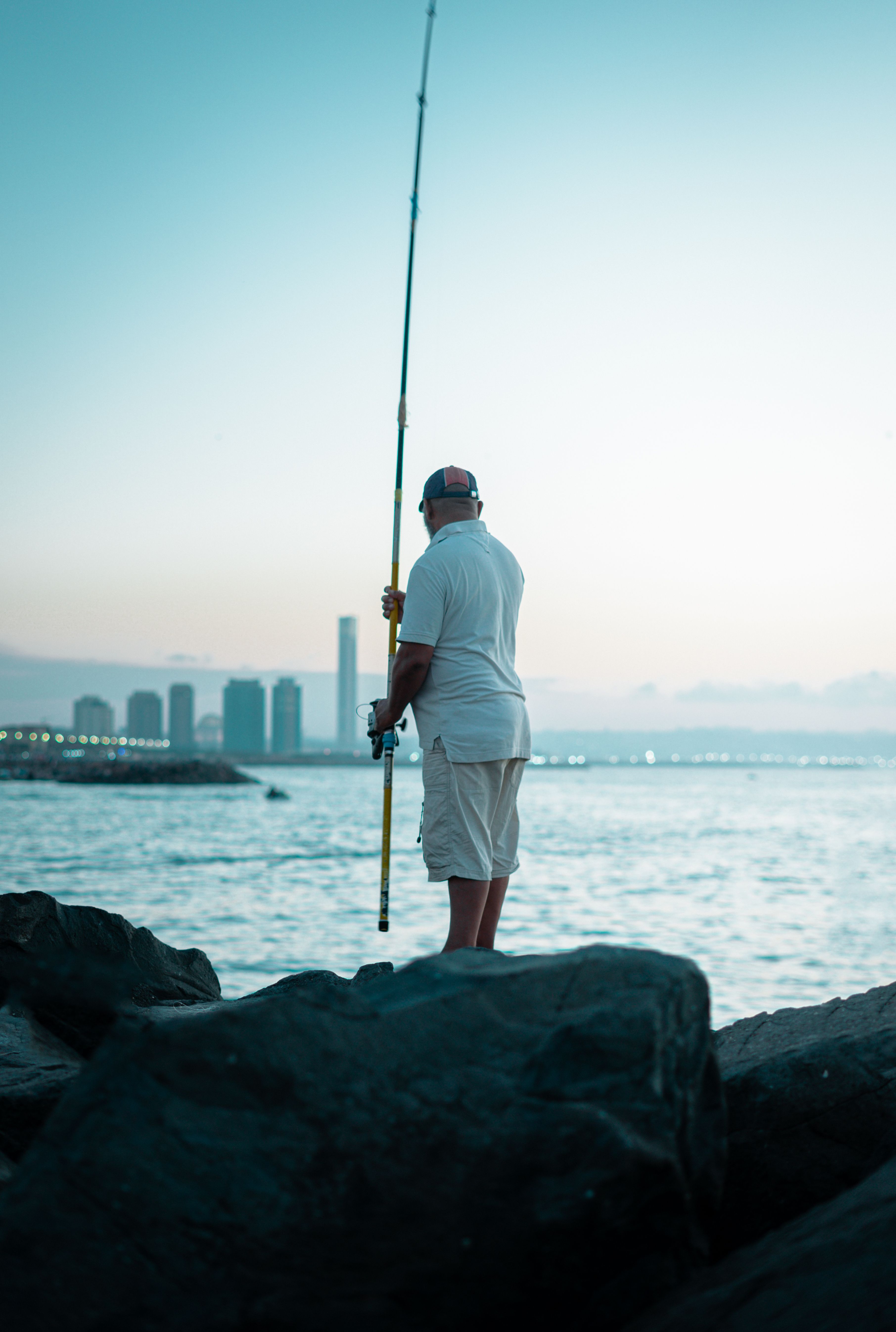 Fisherman in Jacket Standing with Fishing Rod · Free Stock Photo