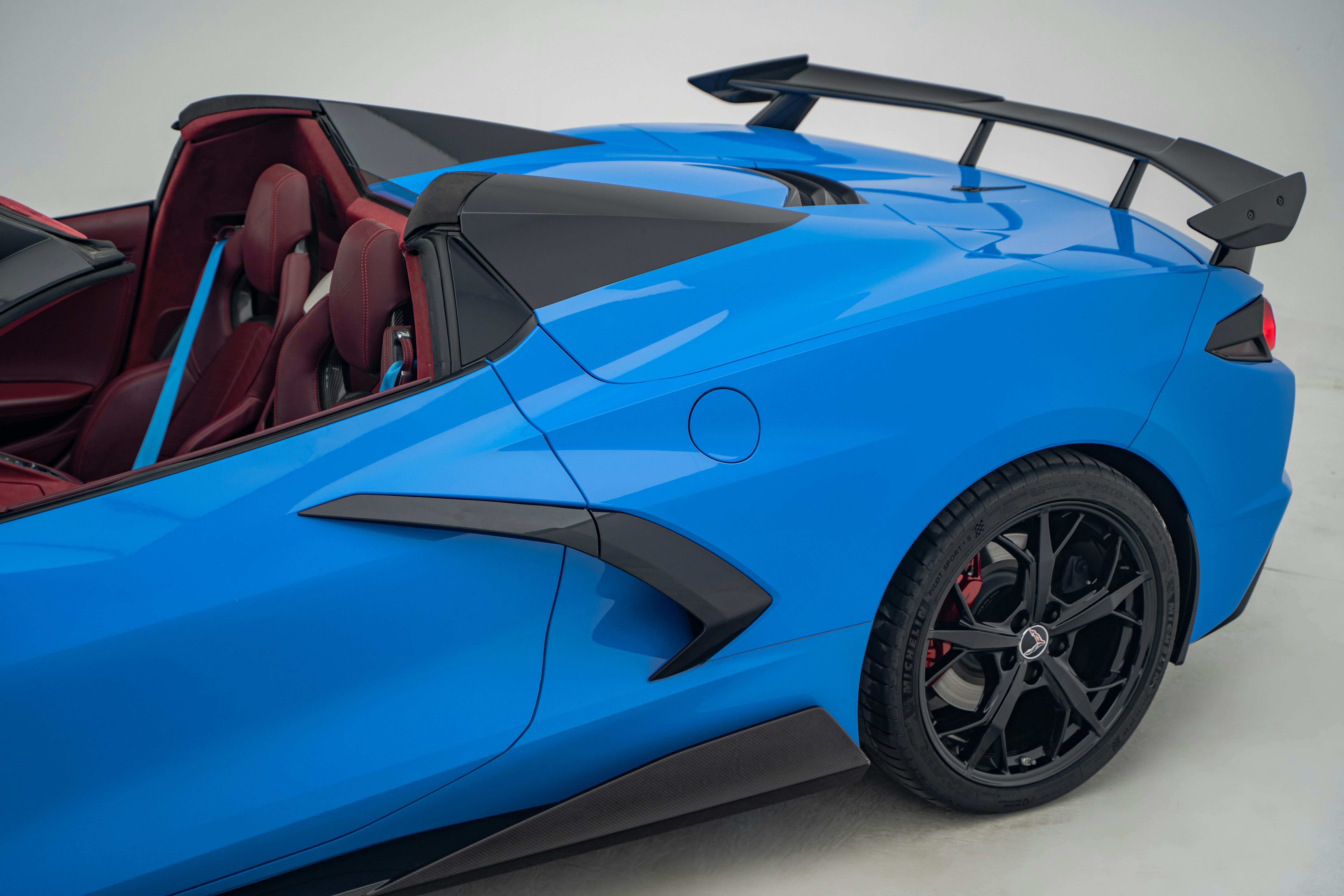 Man with a Camera Sitting on the Hood of a Black Chevrolet Corvette C8 ...