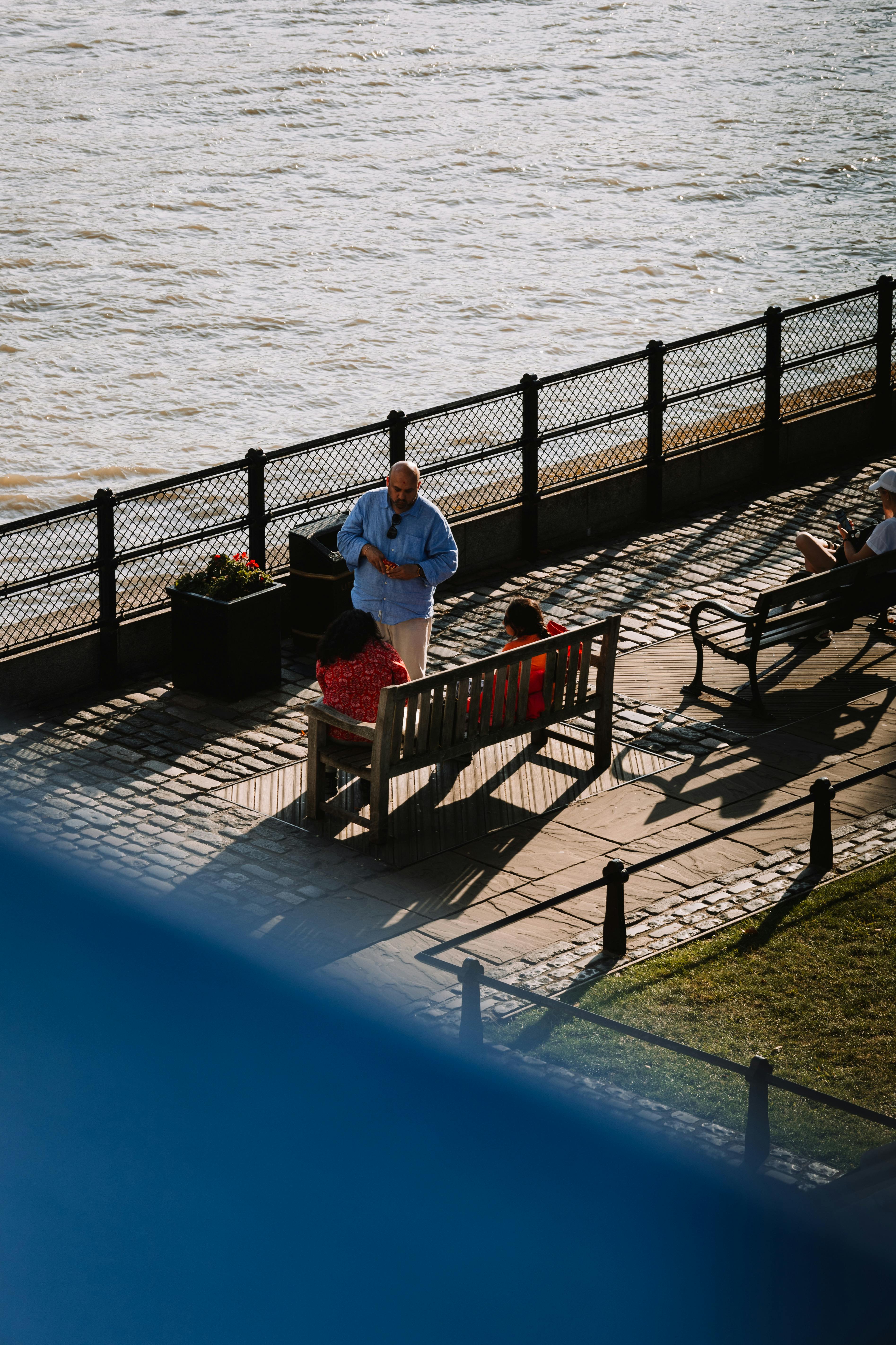 People Standing and Sitting on Promenade · Free Stock Photo
