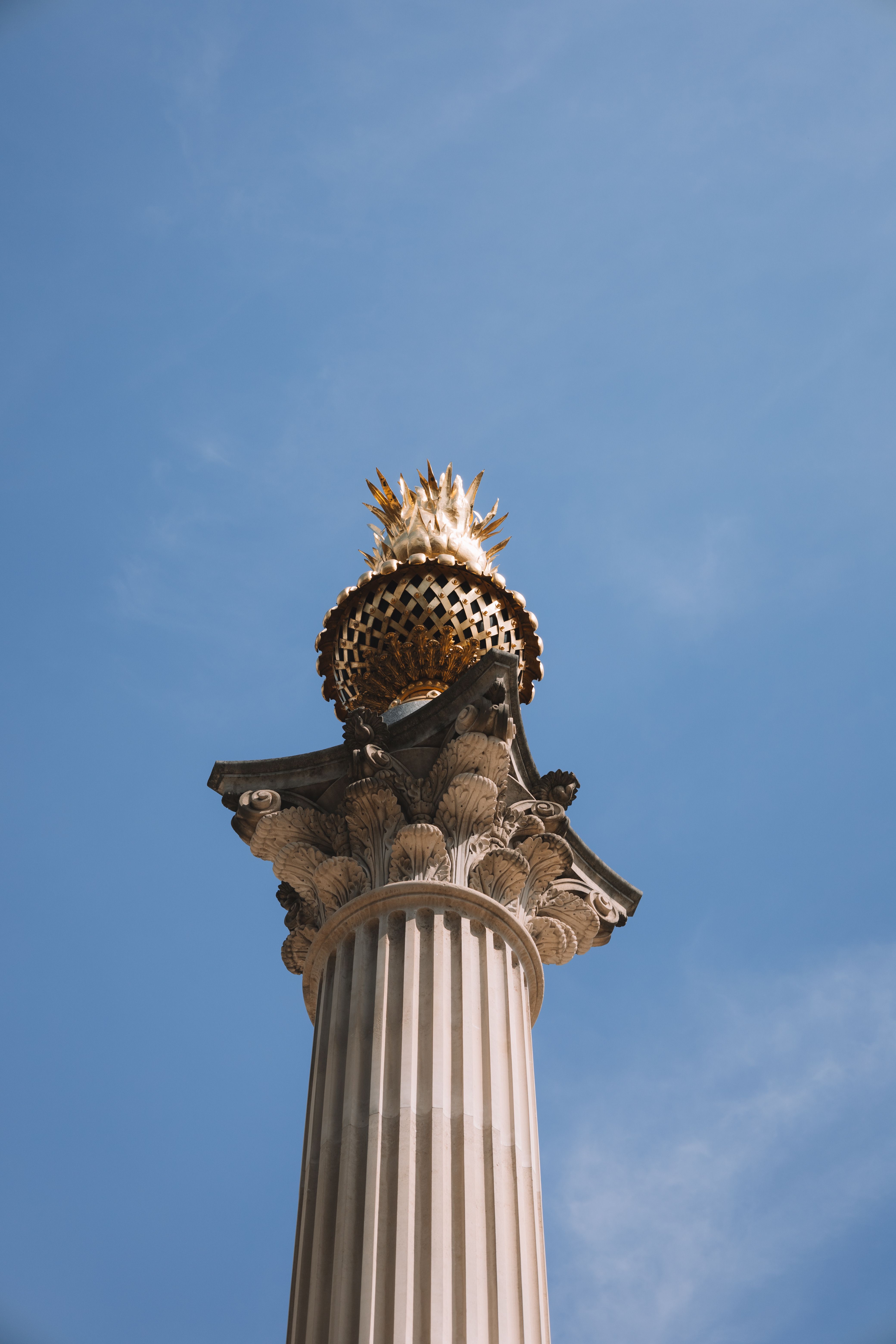 Low Angle Shot of a Column with a Golden Torch · Free Stock Photo