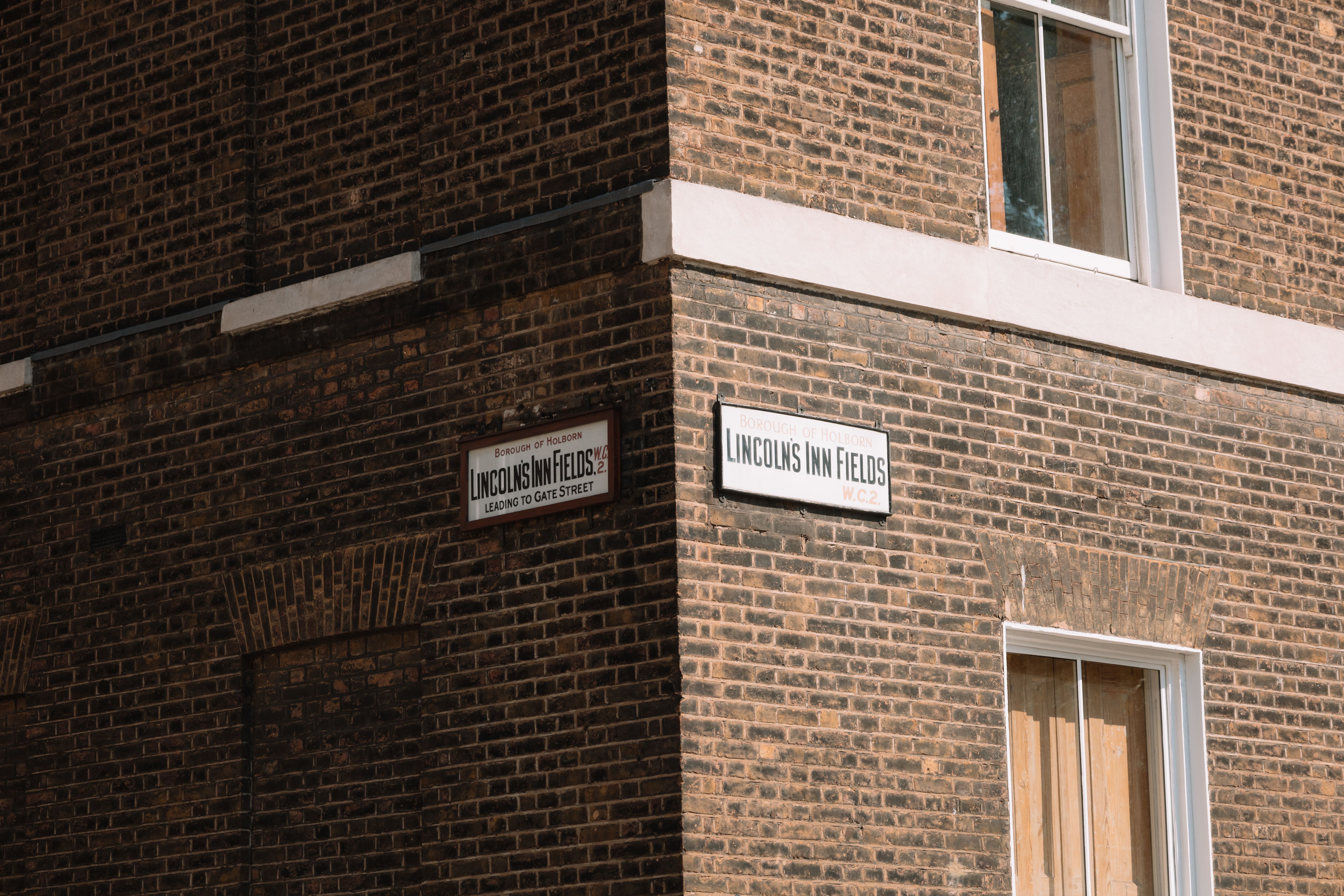 Closeup of a Brick Building Corner with Streets Name Signs · Free Stock ...