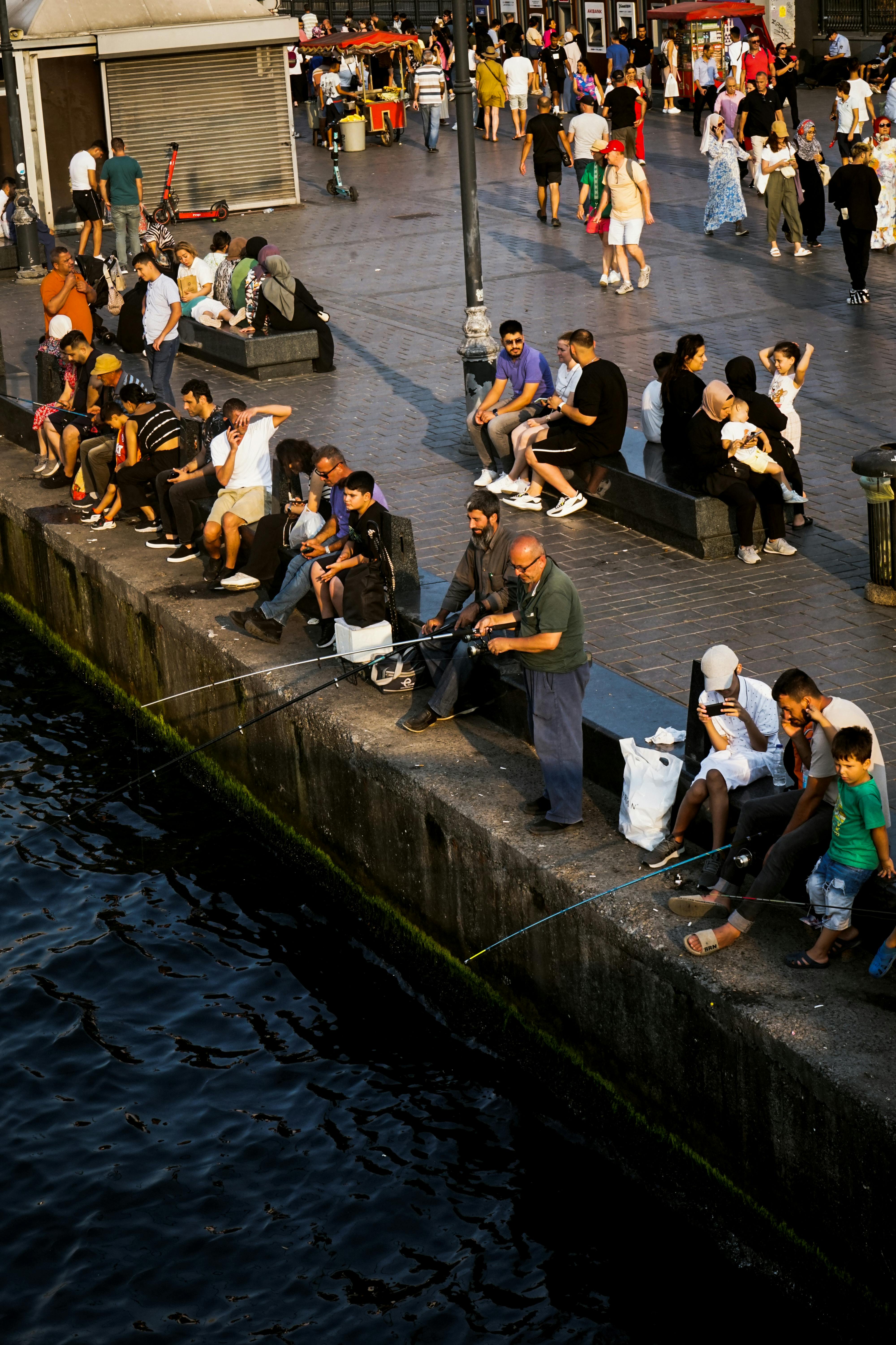 Men Fishing from a Busy Waterfront · Free Stock Photo