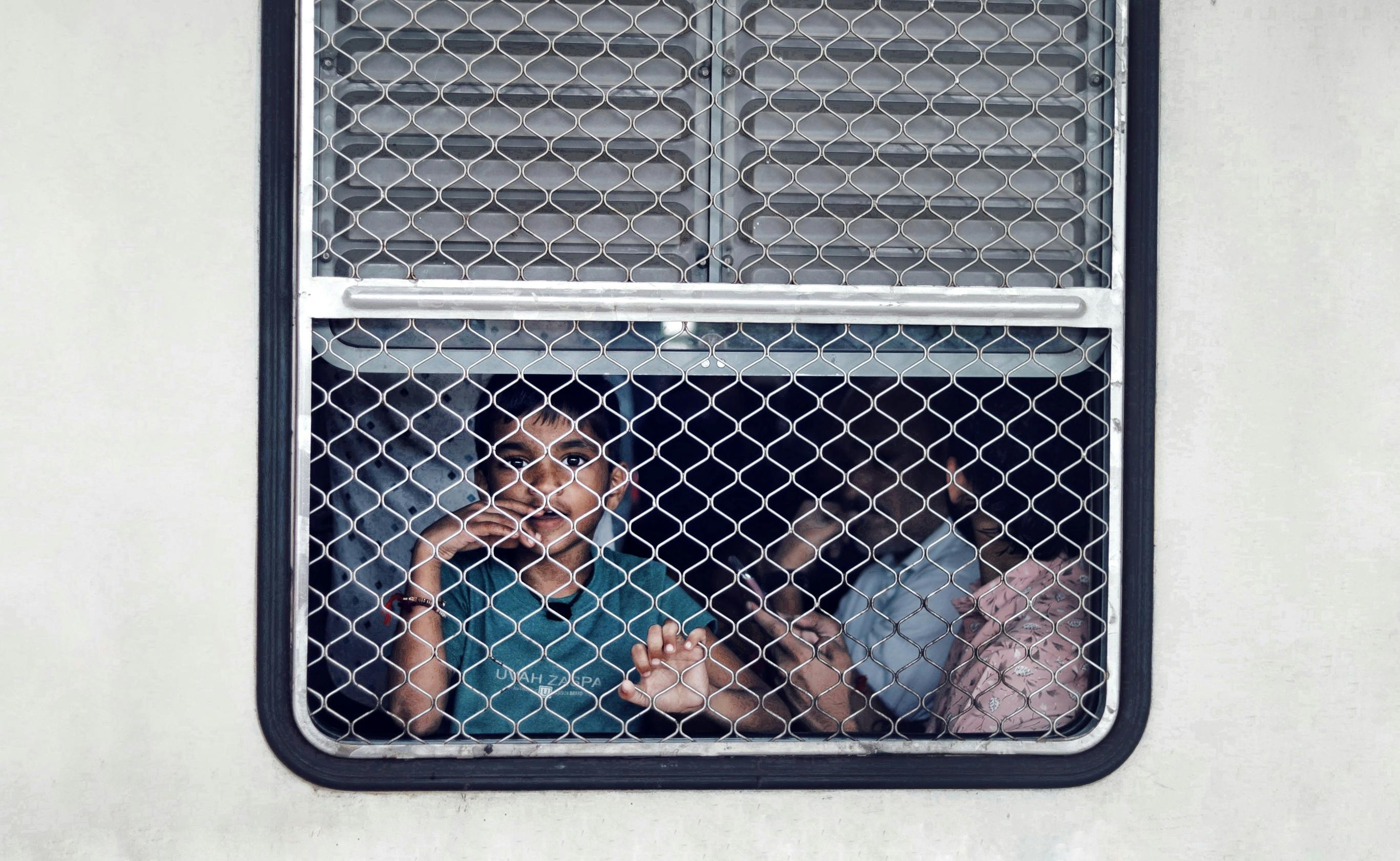 Portrait of a Little Boy Looking out a Train Window · Free Stock Photo