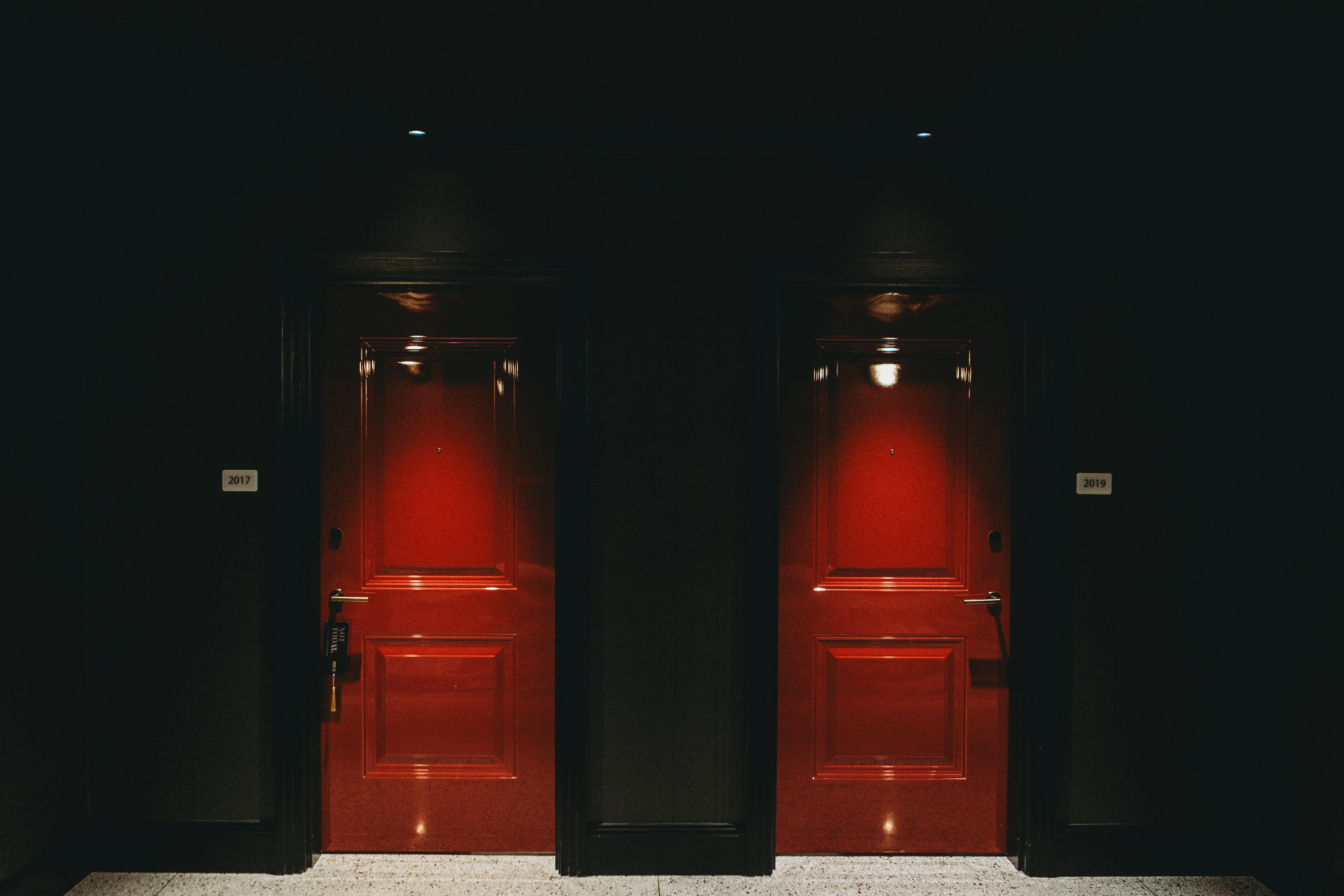 Two red doors in a dark room with black walls · Free Stock Photo
