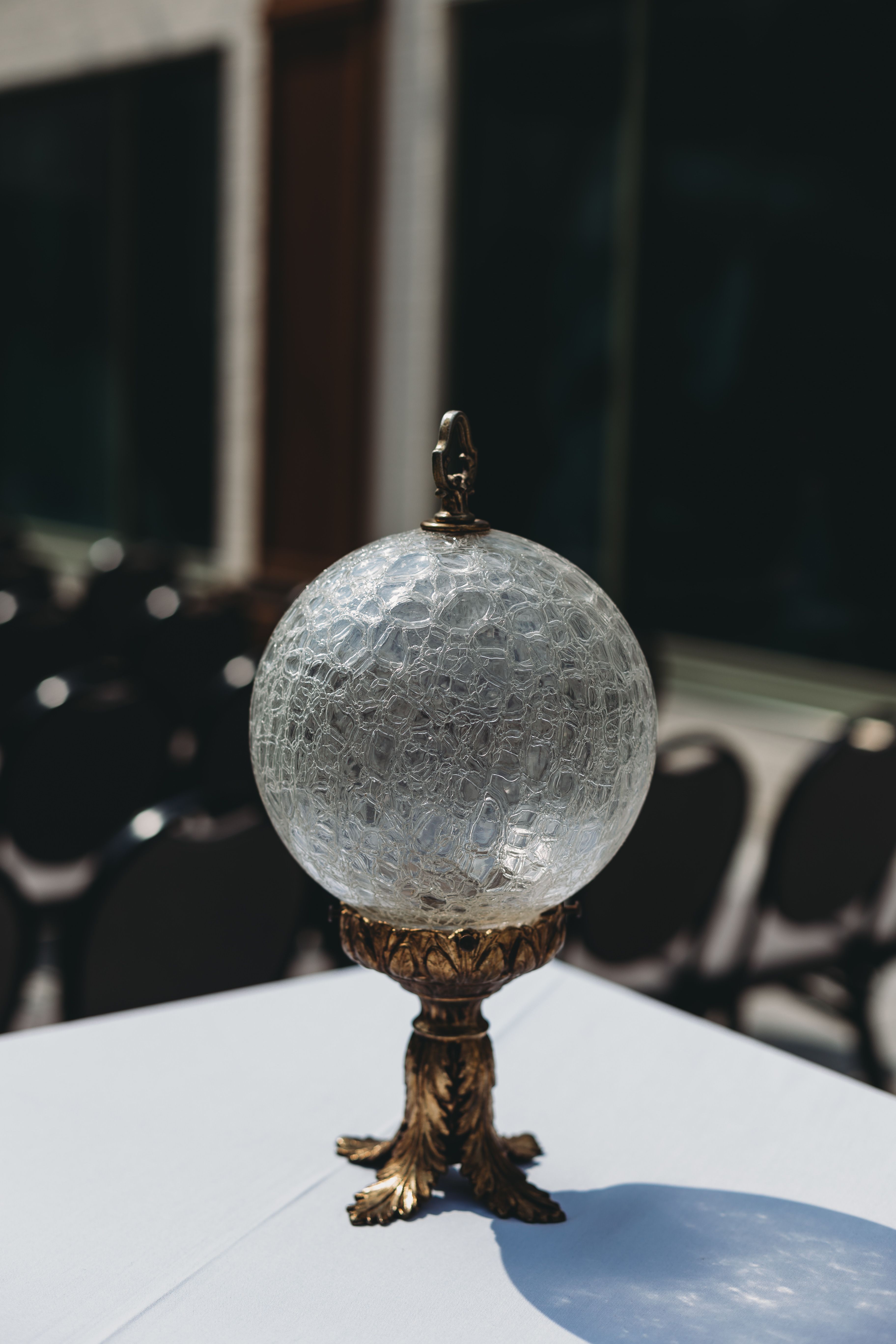 A glass globe on a table with a white tablecloth · Free Stock Photo
