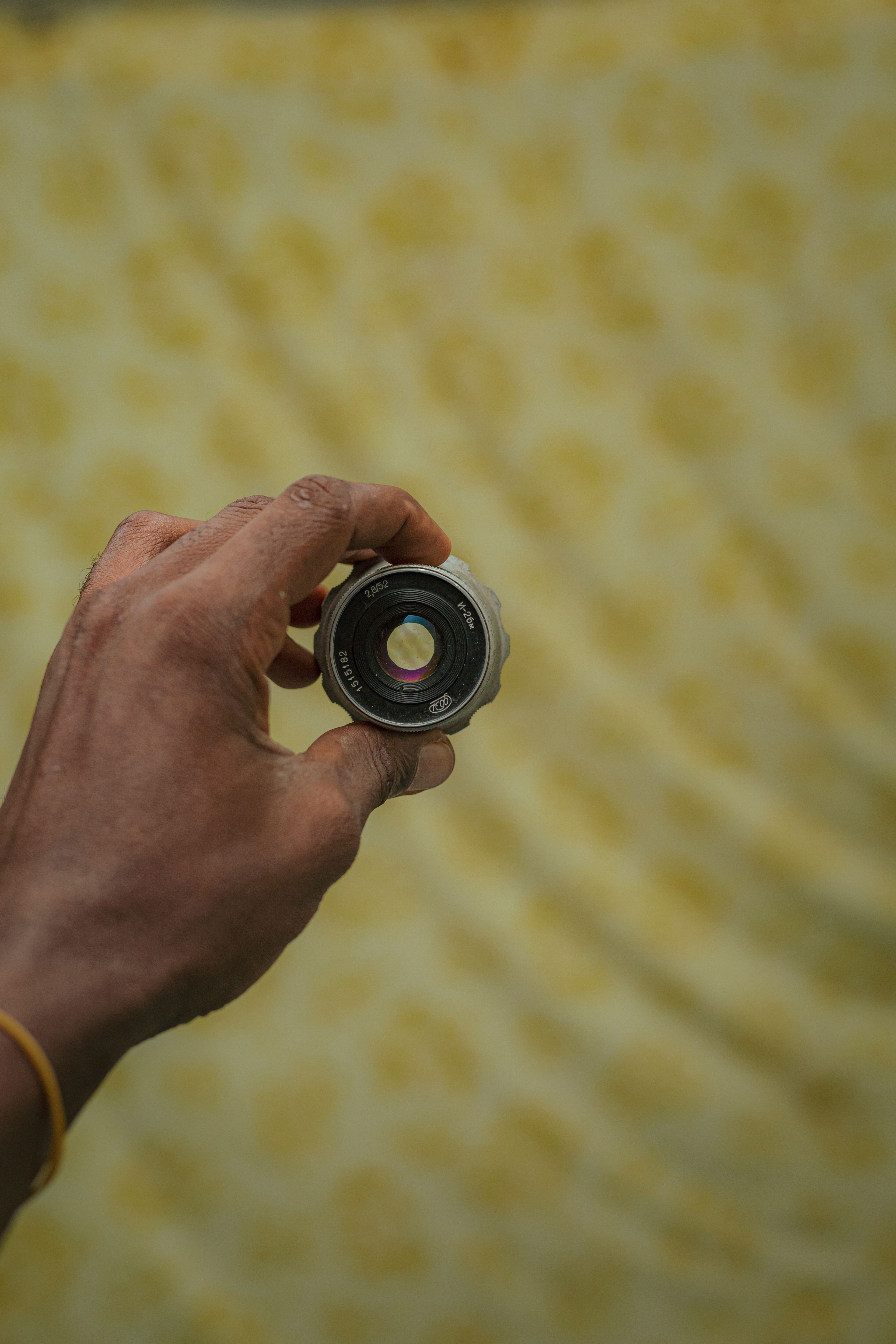 Close-up of Man Holding a Camera Lens · Free Stock Photo