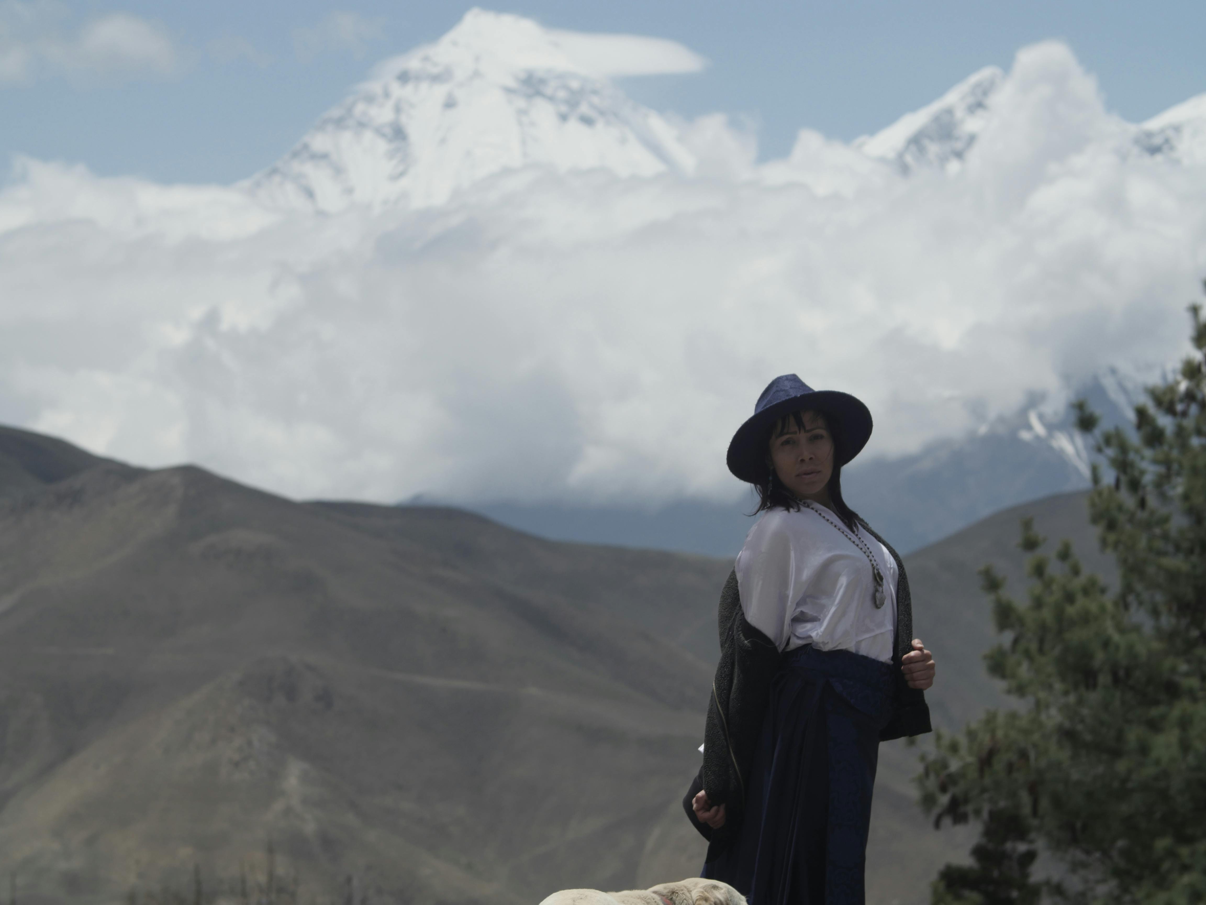 Woman in Fedora Hat Posing against Mountains · Free Stock Photo