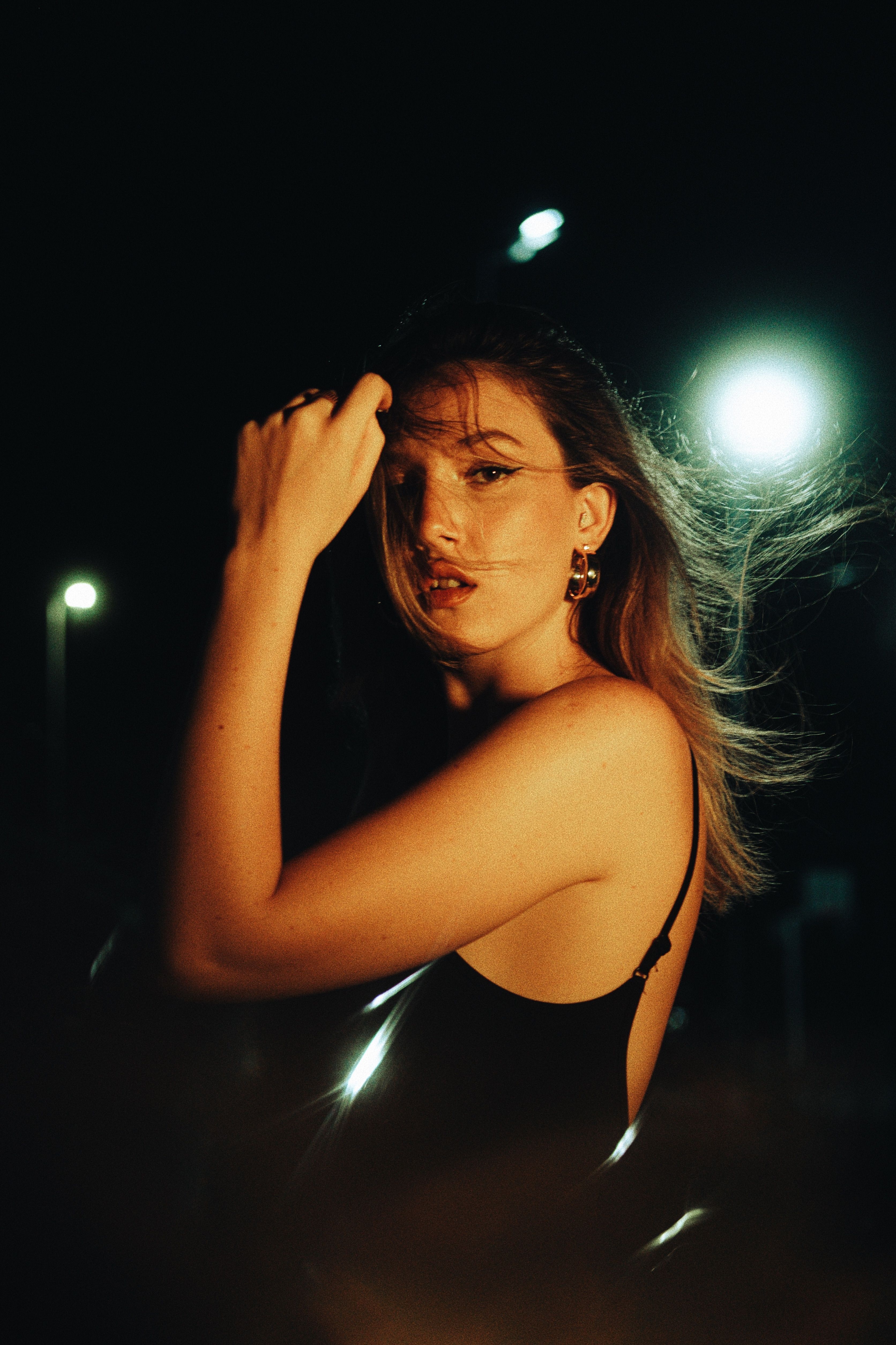 Woman Fixing Hair at Night · Free Stock Photo