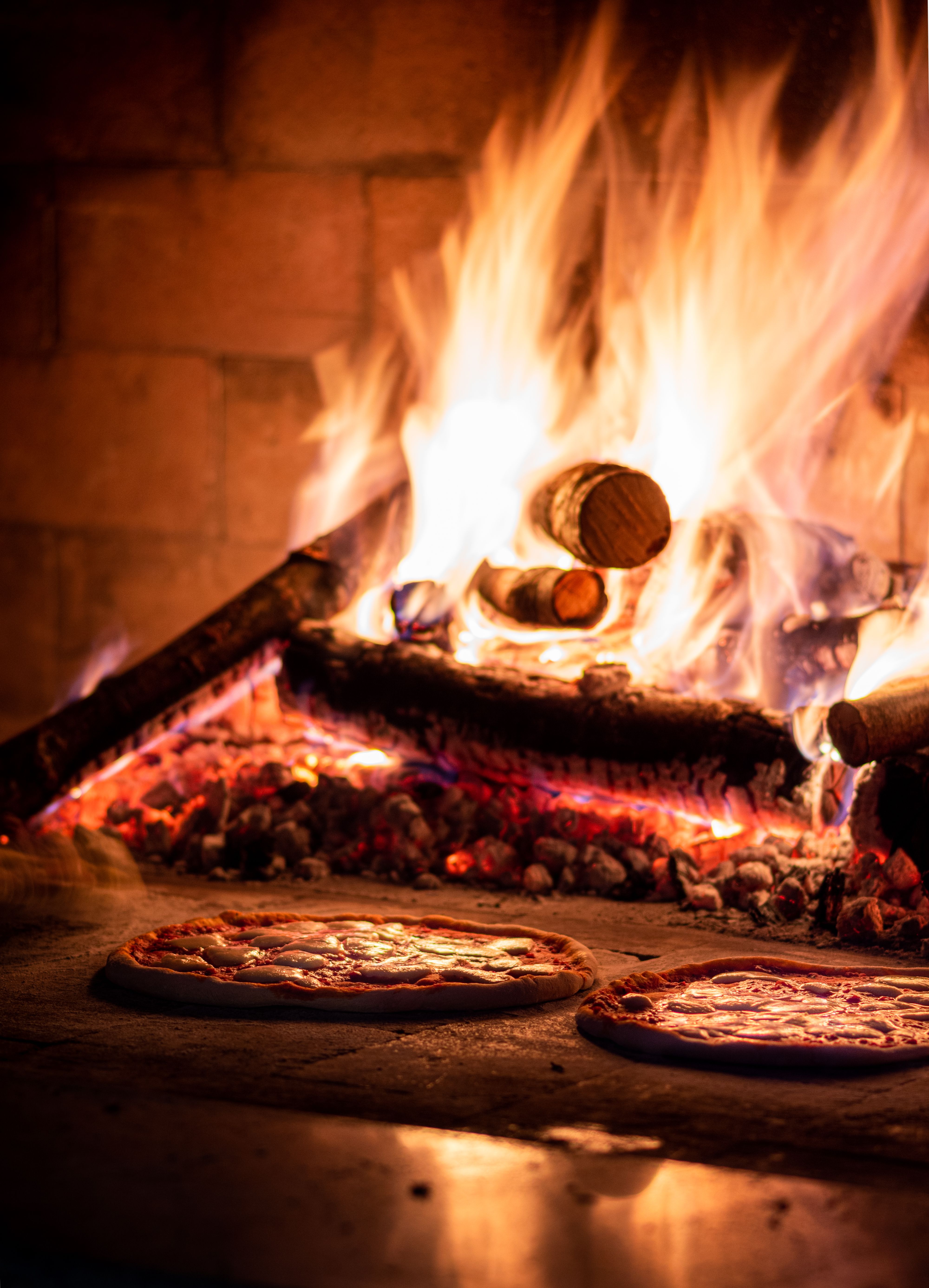 Pizzas in a stone oven with a fire · Free Stock Photo