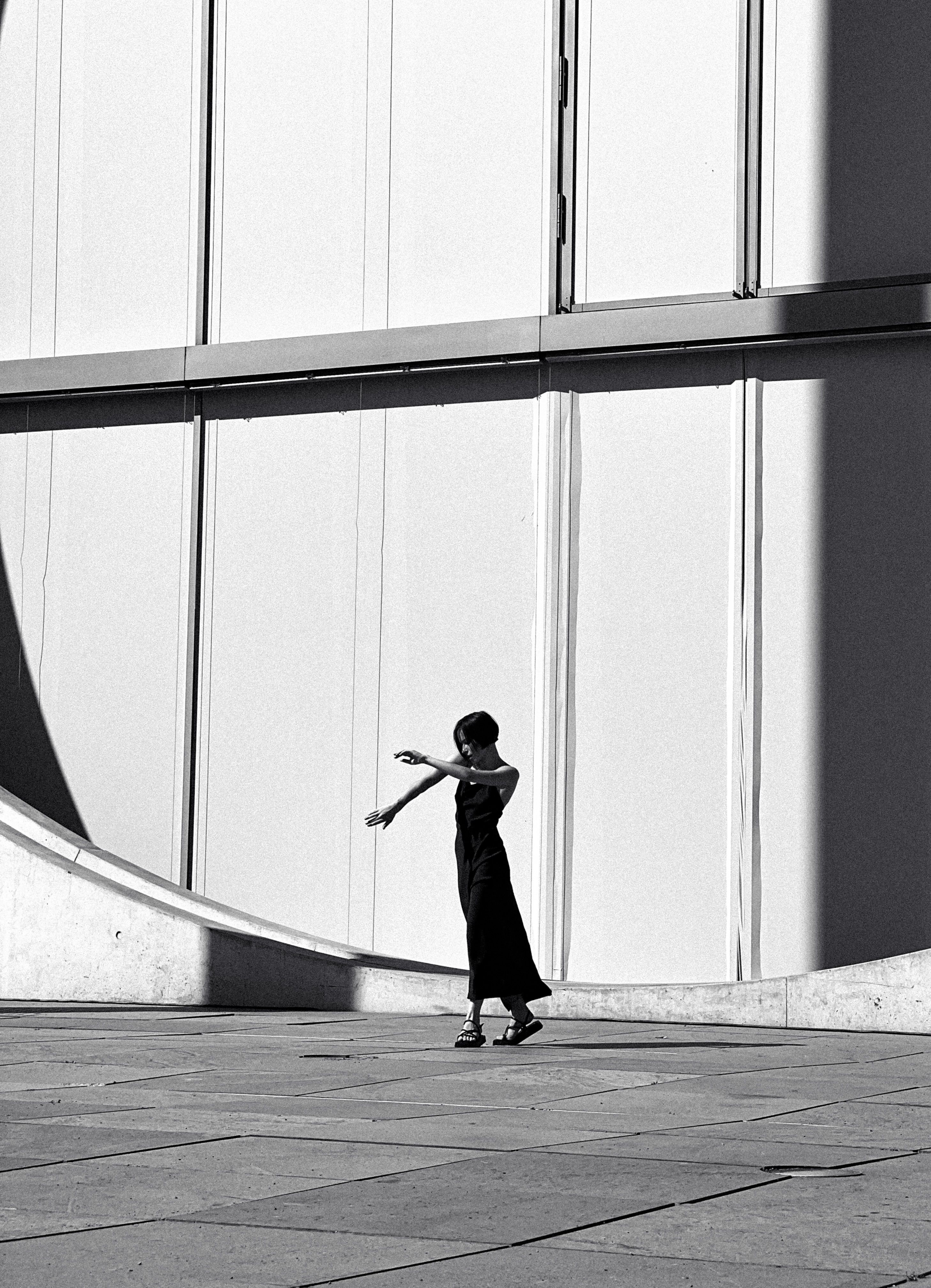 A Woman Walking in front of a Modern Building · Free Stock Photo