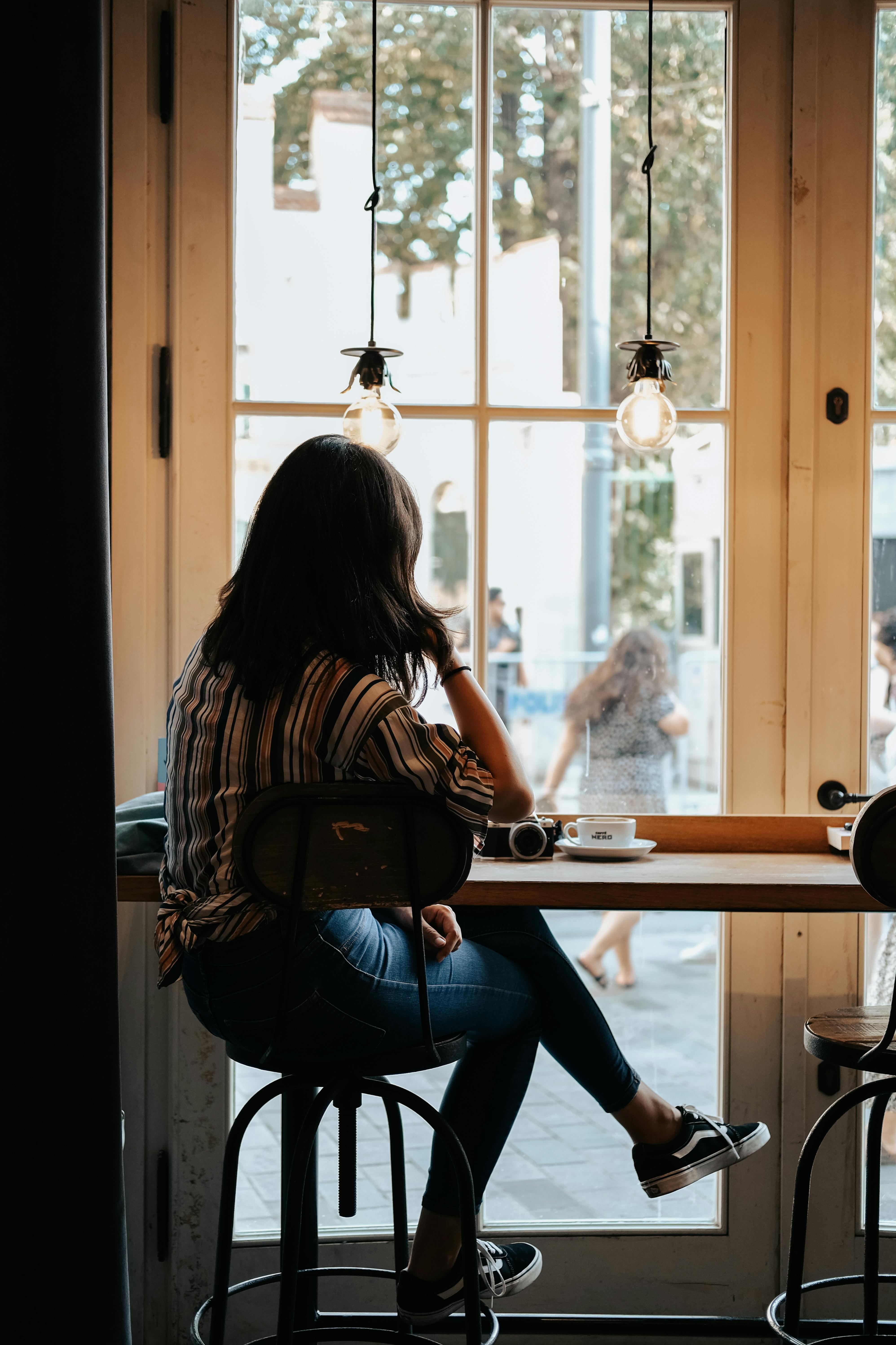 Woman Sitting by Table near Windows · Free Stock Photo