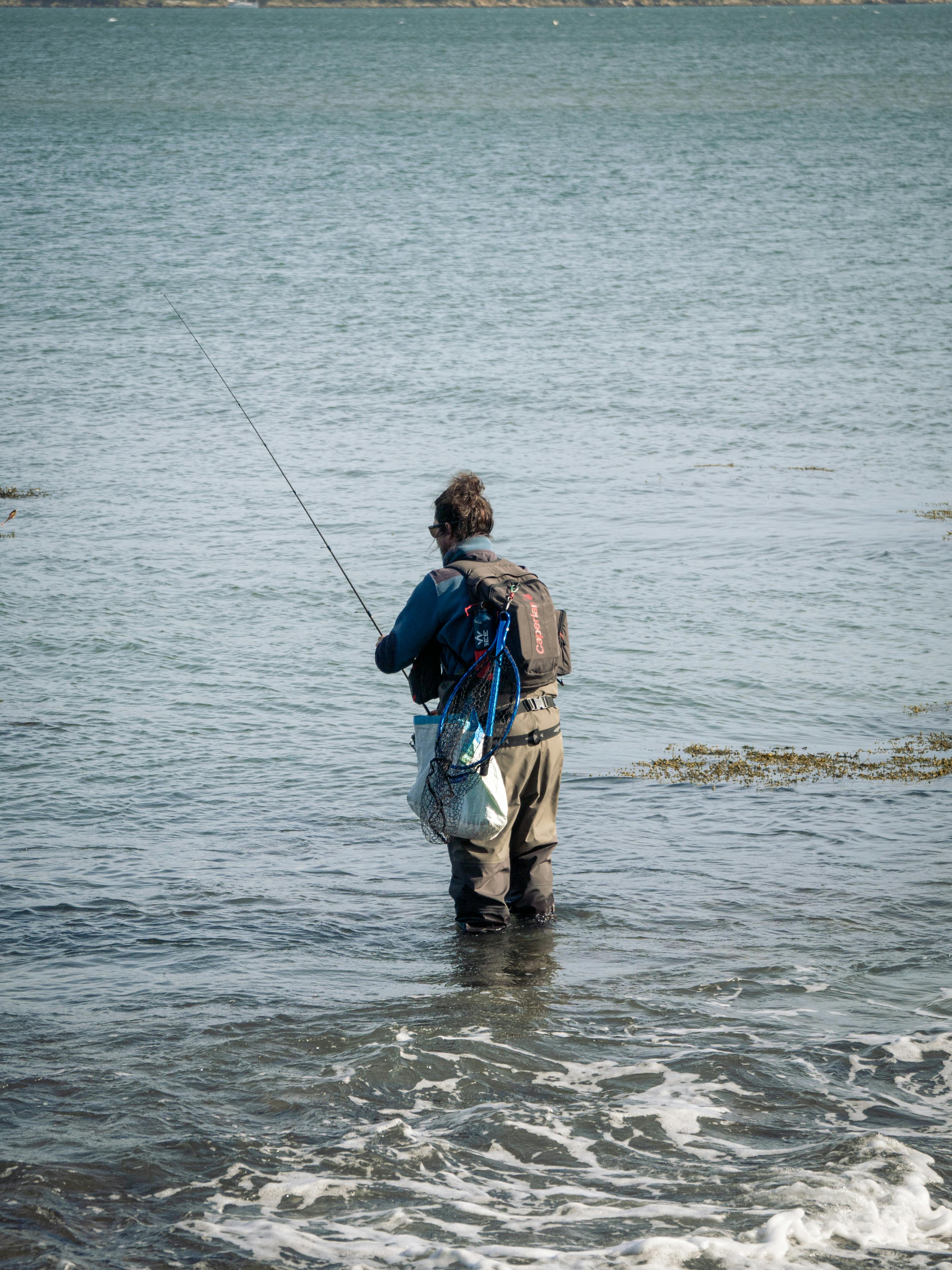 A Fisherman Surf Casting at the Beach · Free Stock Photo