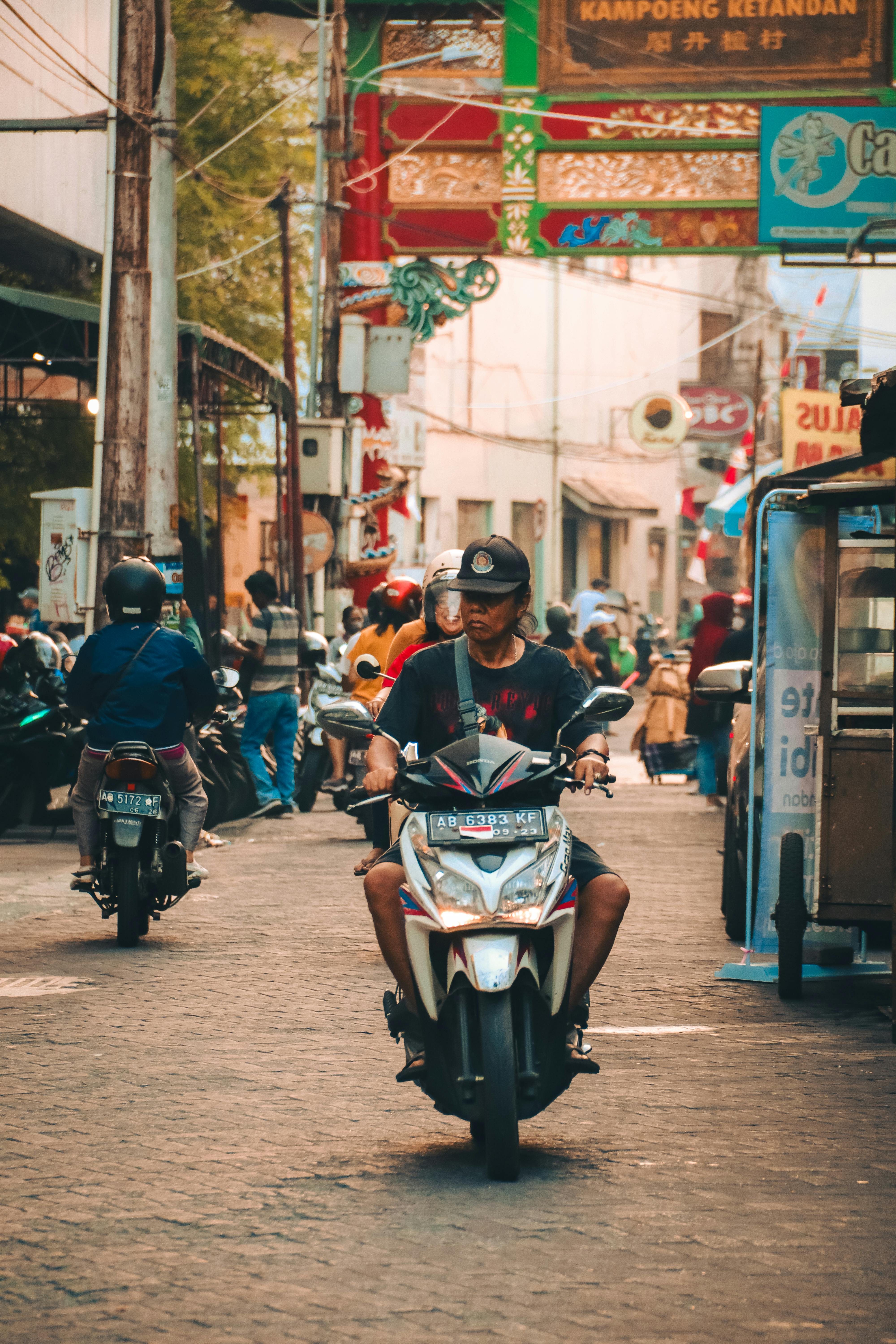 Man Riding Motor Scooter in Alley in Town · Free Stock Photo